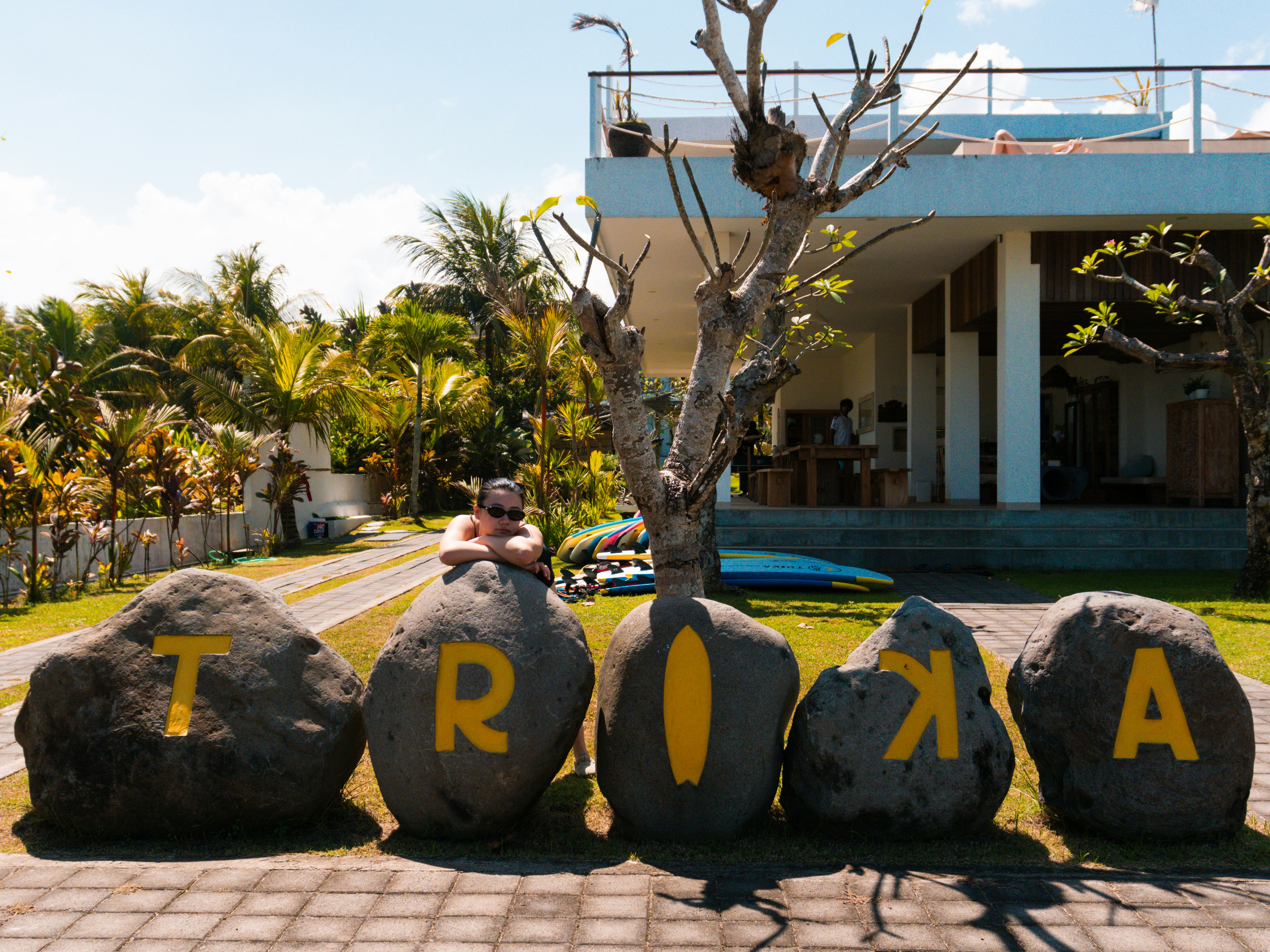 Rock Letters and Lounging Visitor at a Sunlit Resort
