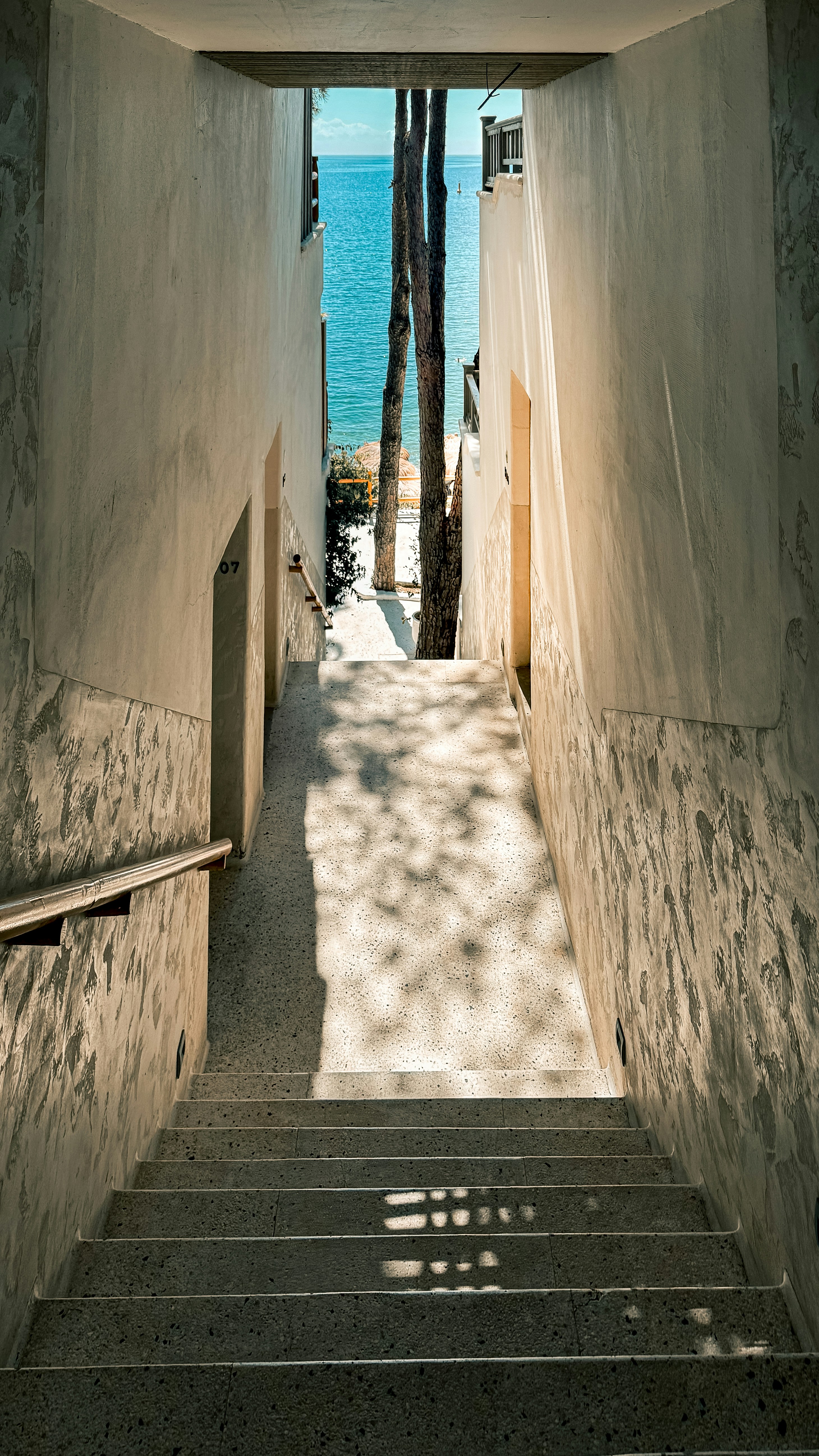 Staircase to the Sea: Light and Shadow Through a Narrow Passage