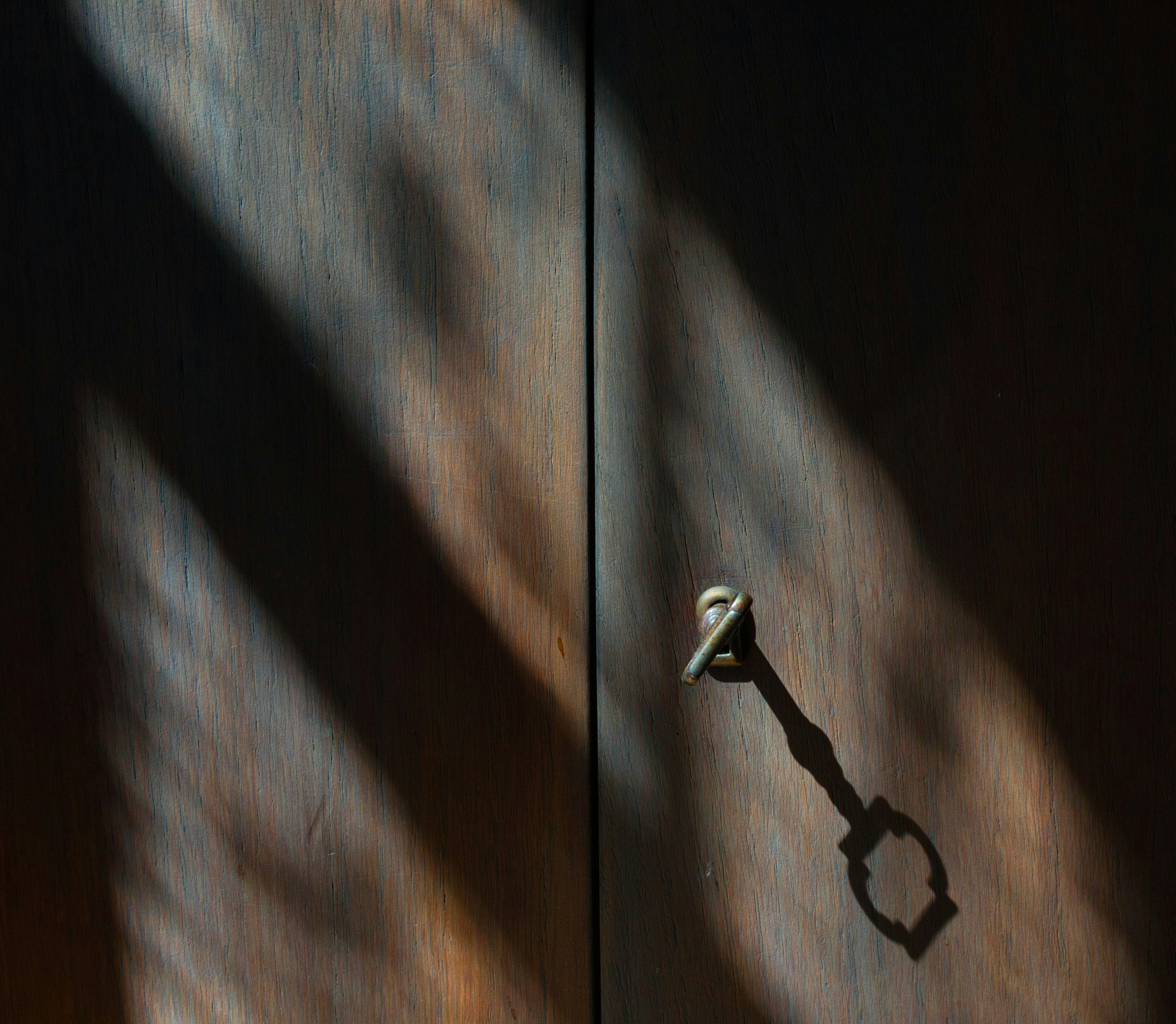 Shadowed Key on Weathered Wood: A Quiet Doorway