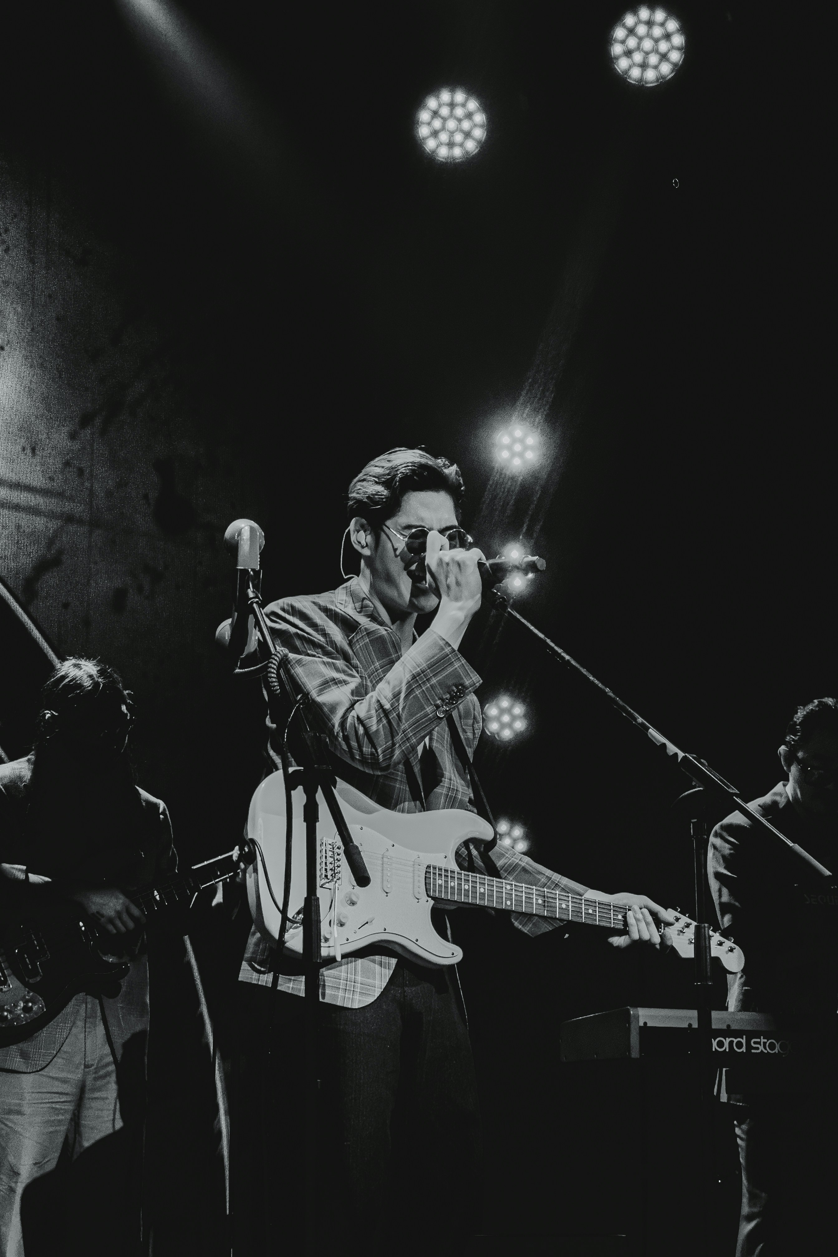 Male musician sings and plays guitar on stage.