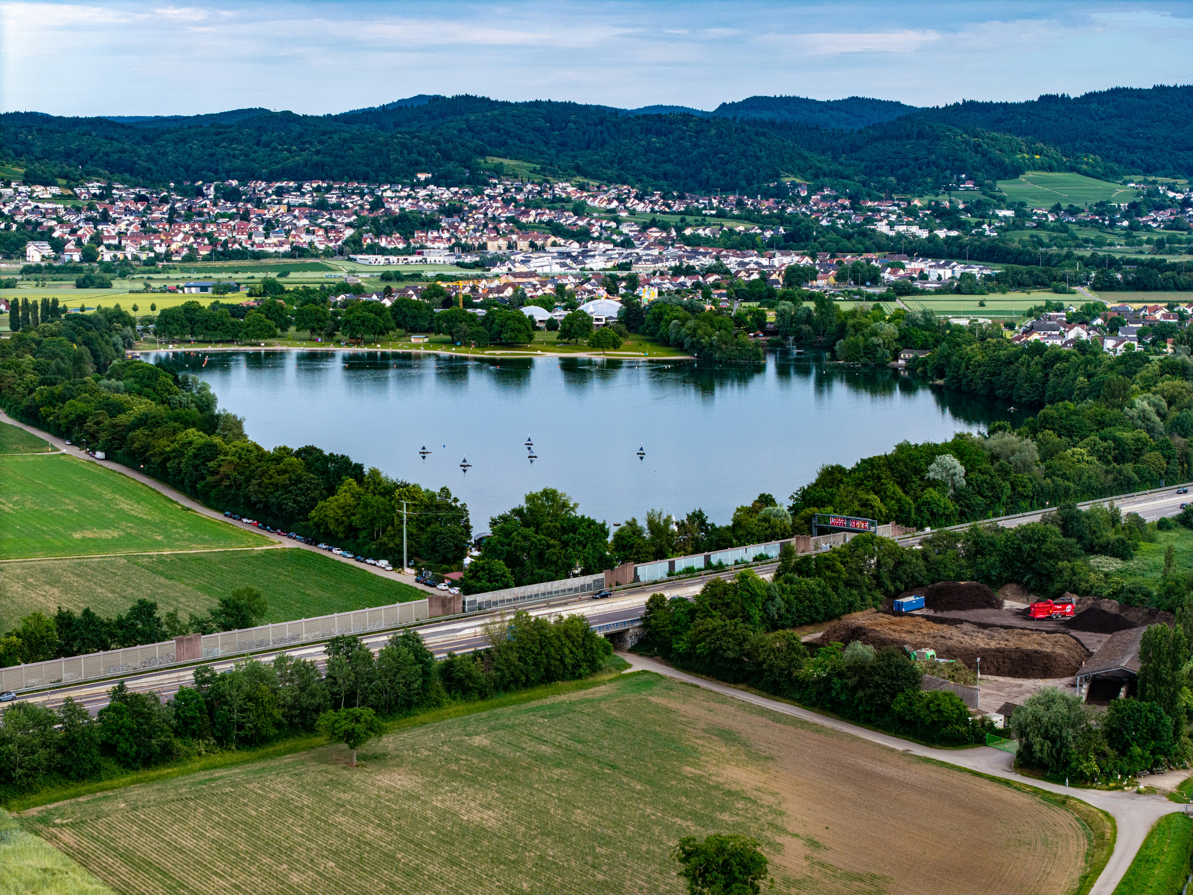 Aerial View of a Lake Encircled by Towns and Green Fields
