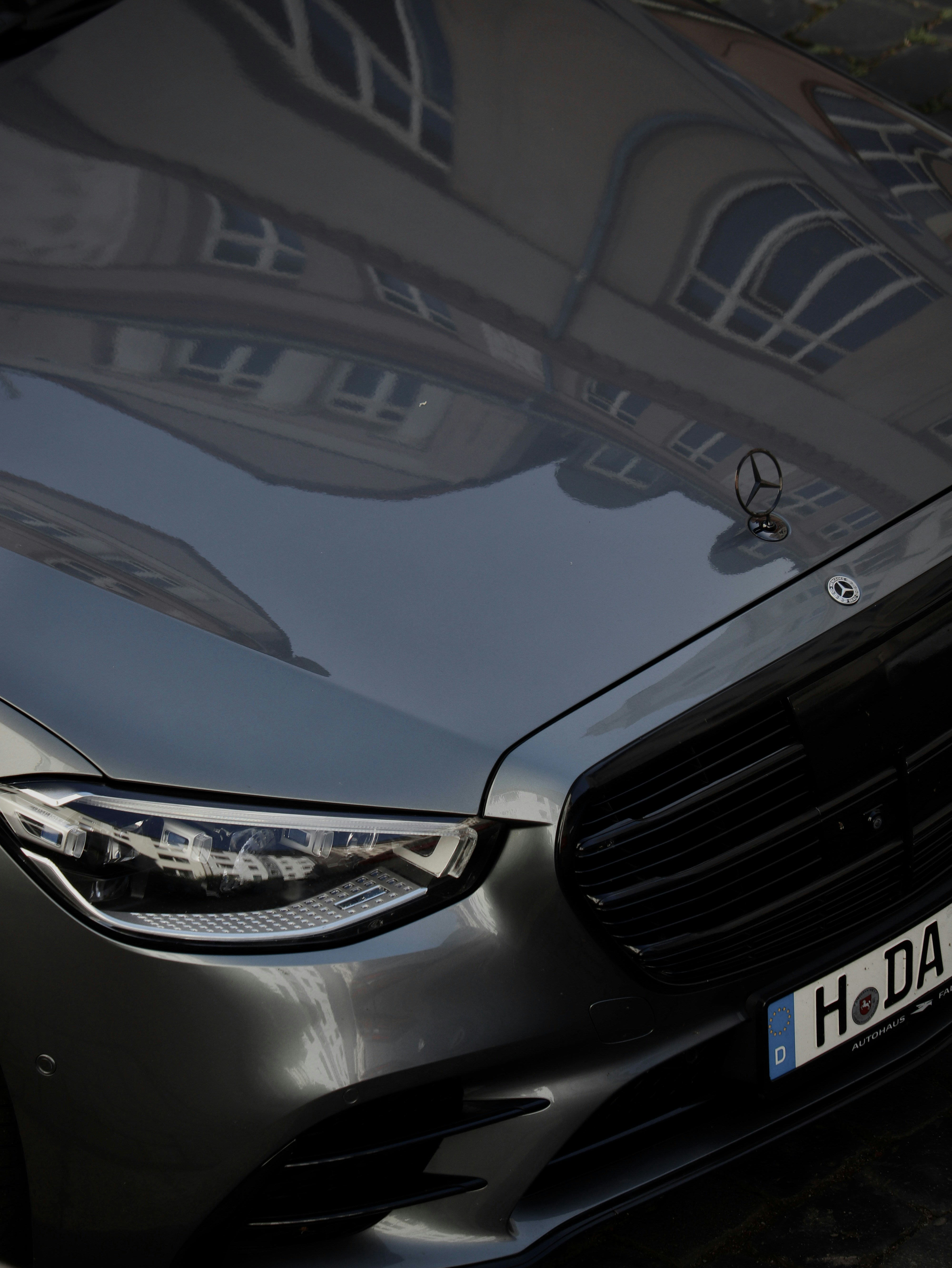 Reflected Facade on a Metallic Grille: A Mercedes-Benz Accent