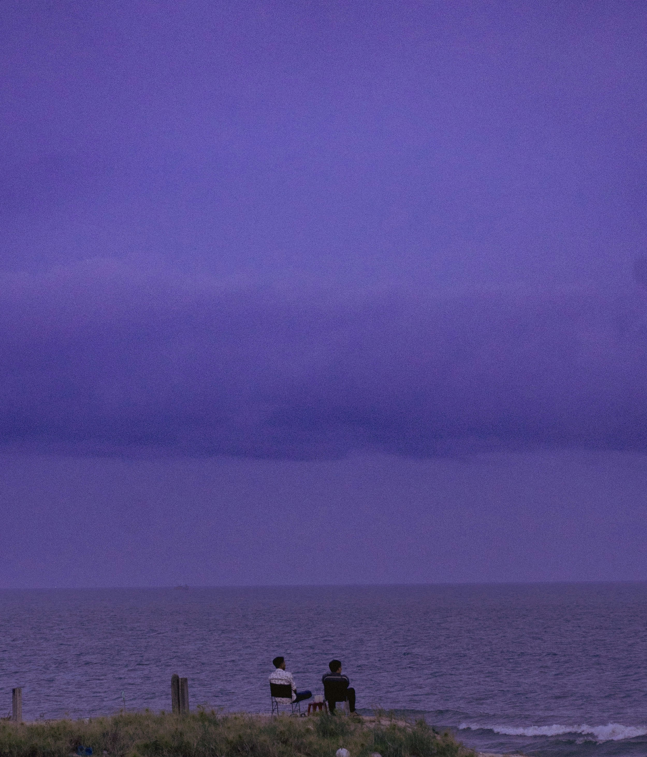 Quiet Horizons: Two Figures on a Distant Shore