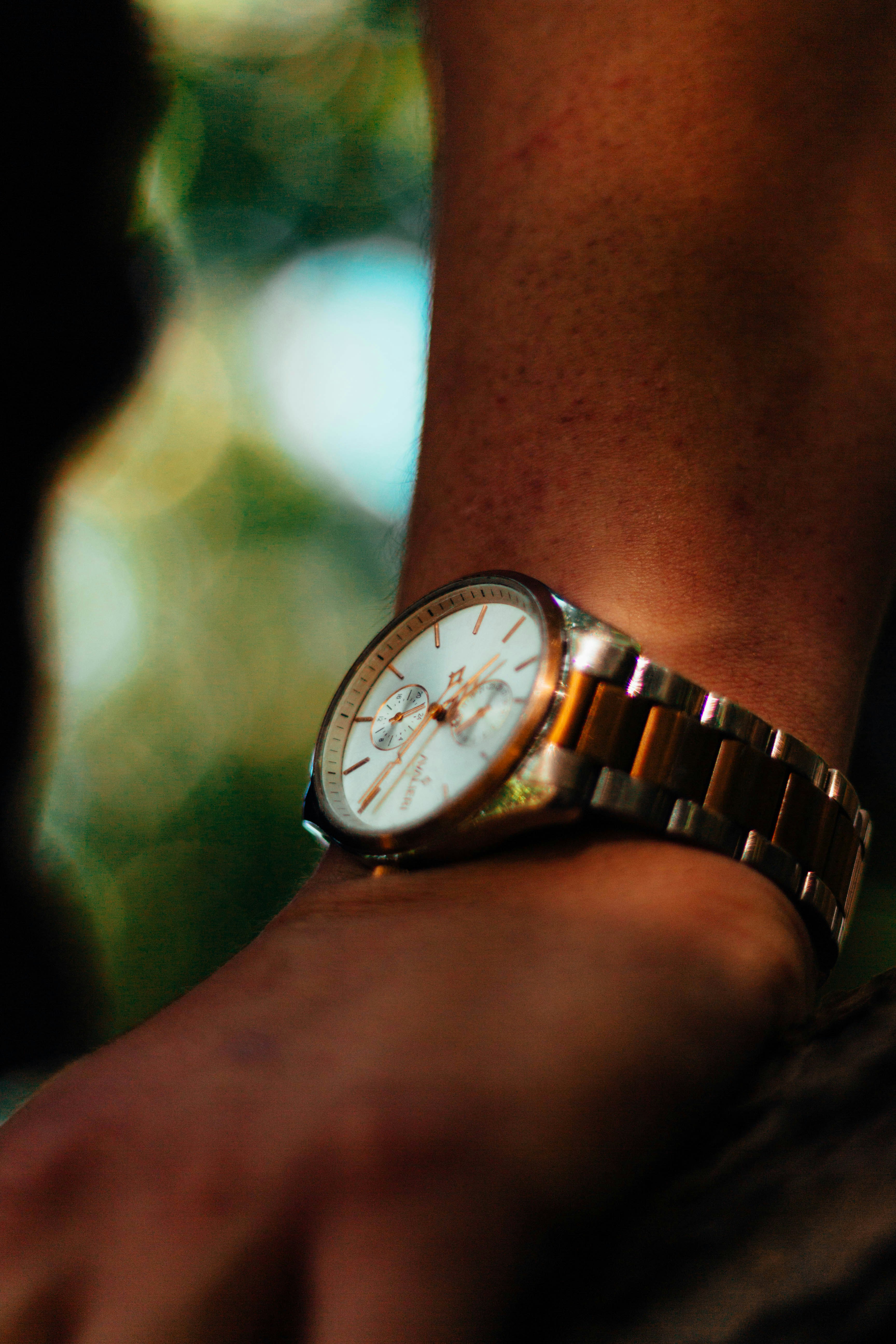Gold-Toned Wristwatch Dangles in Soft Focus Frame