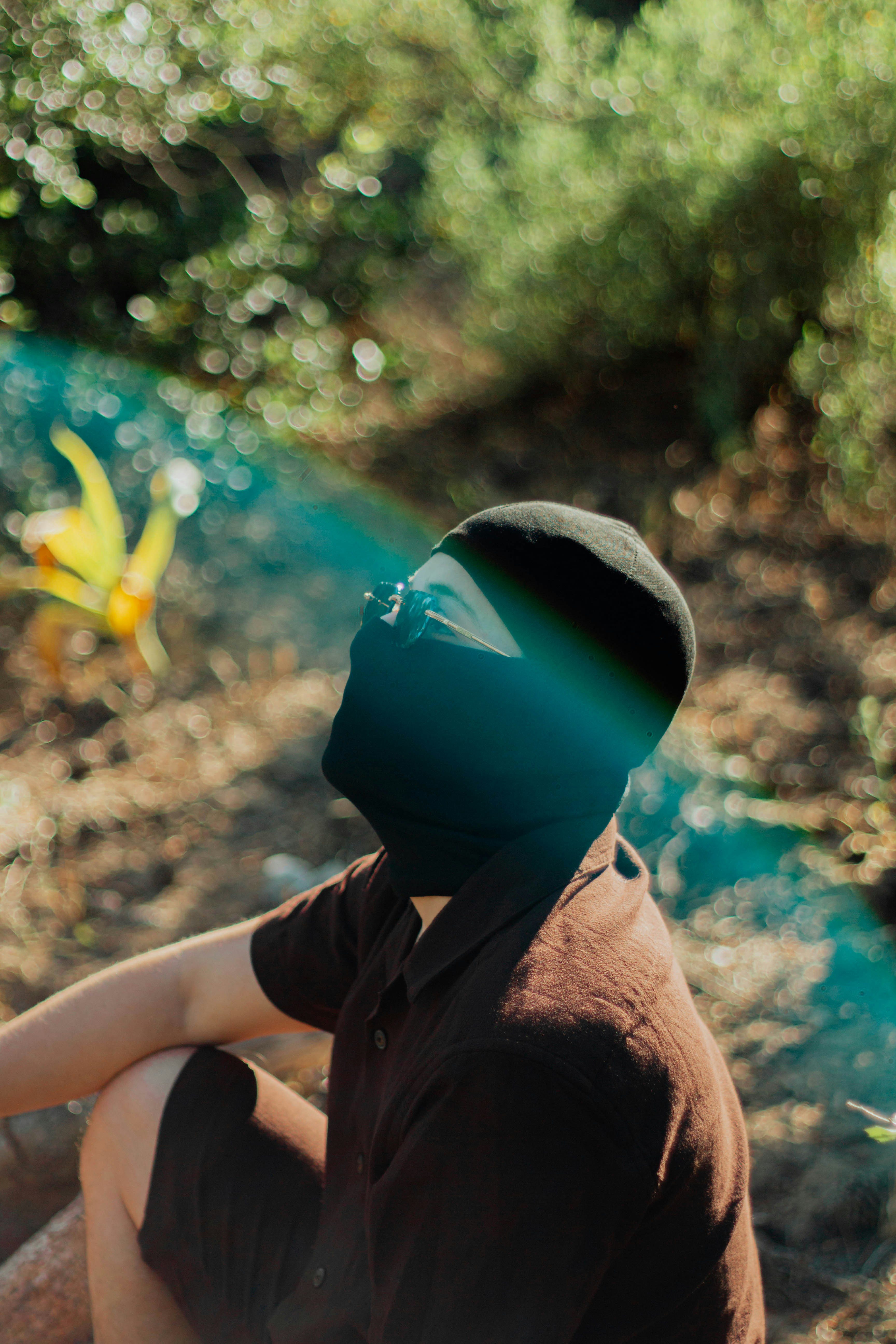 Masked Portrait Beneath a Green Lens Flare
