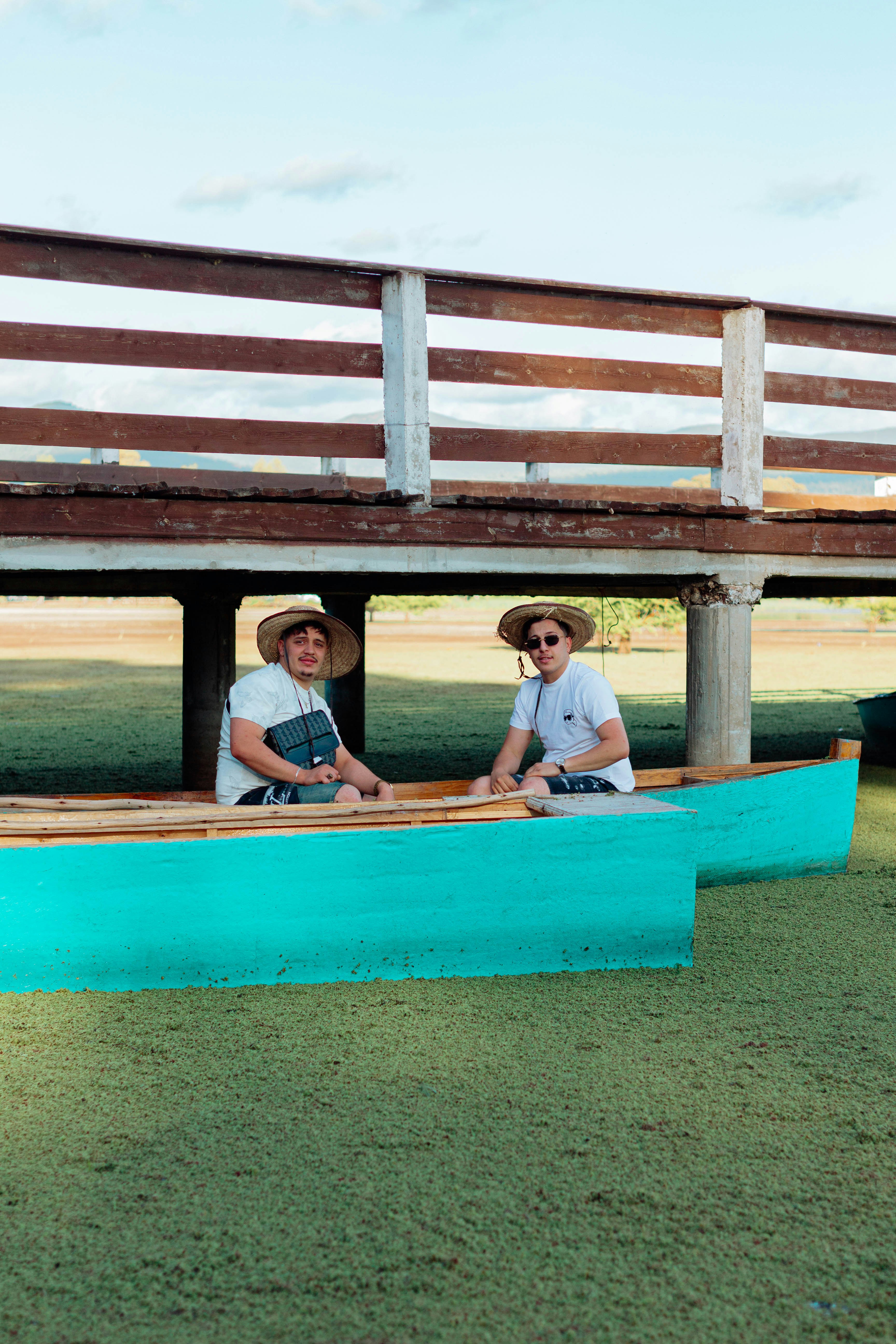 Two Rowers Under a Weathered Pier: Calm Morning by the Canal