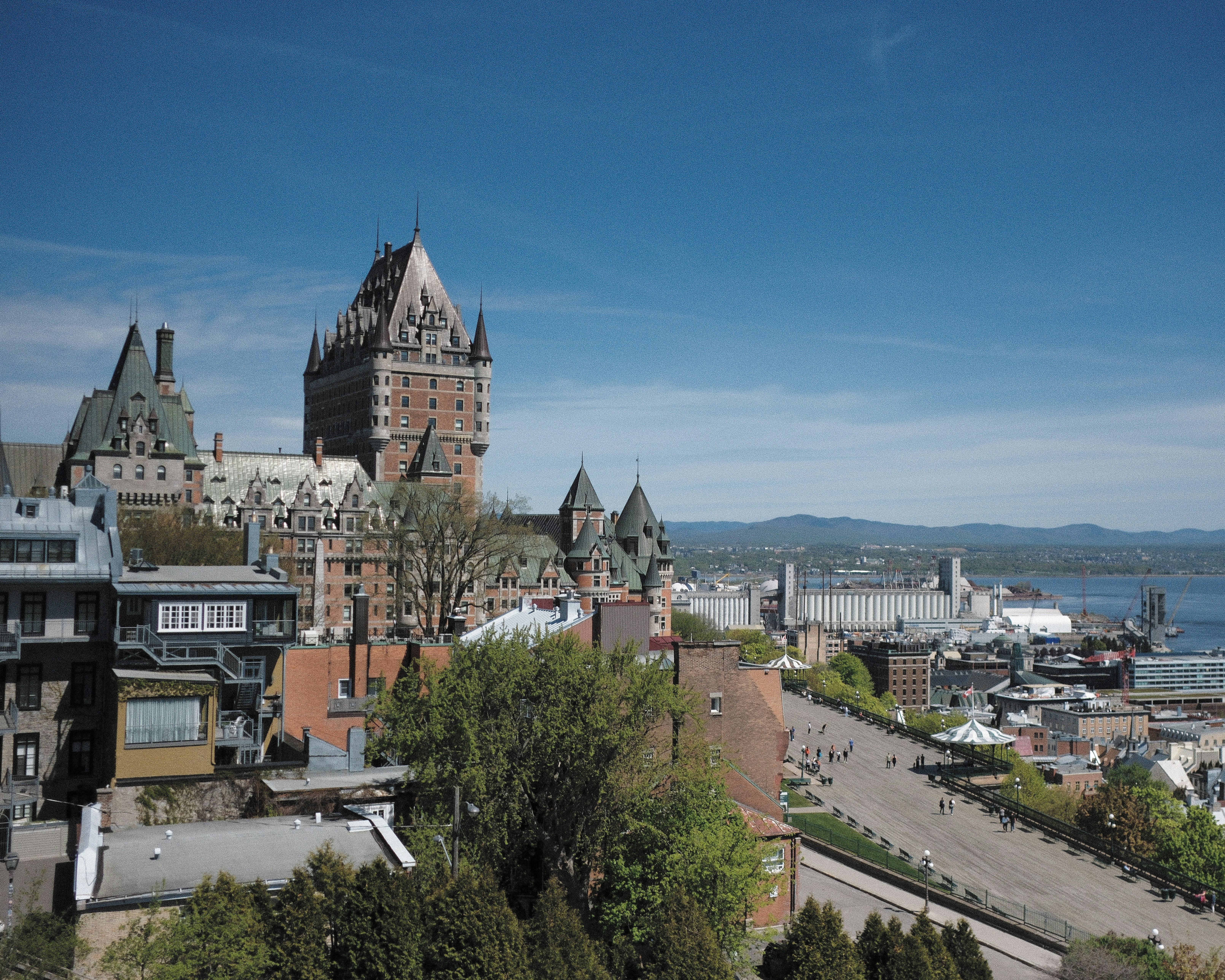 Castle-topped skyline over a sunlit harbor promenade