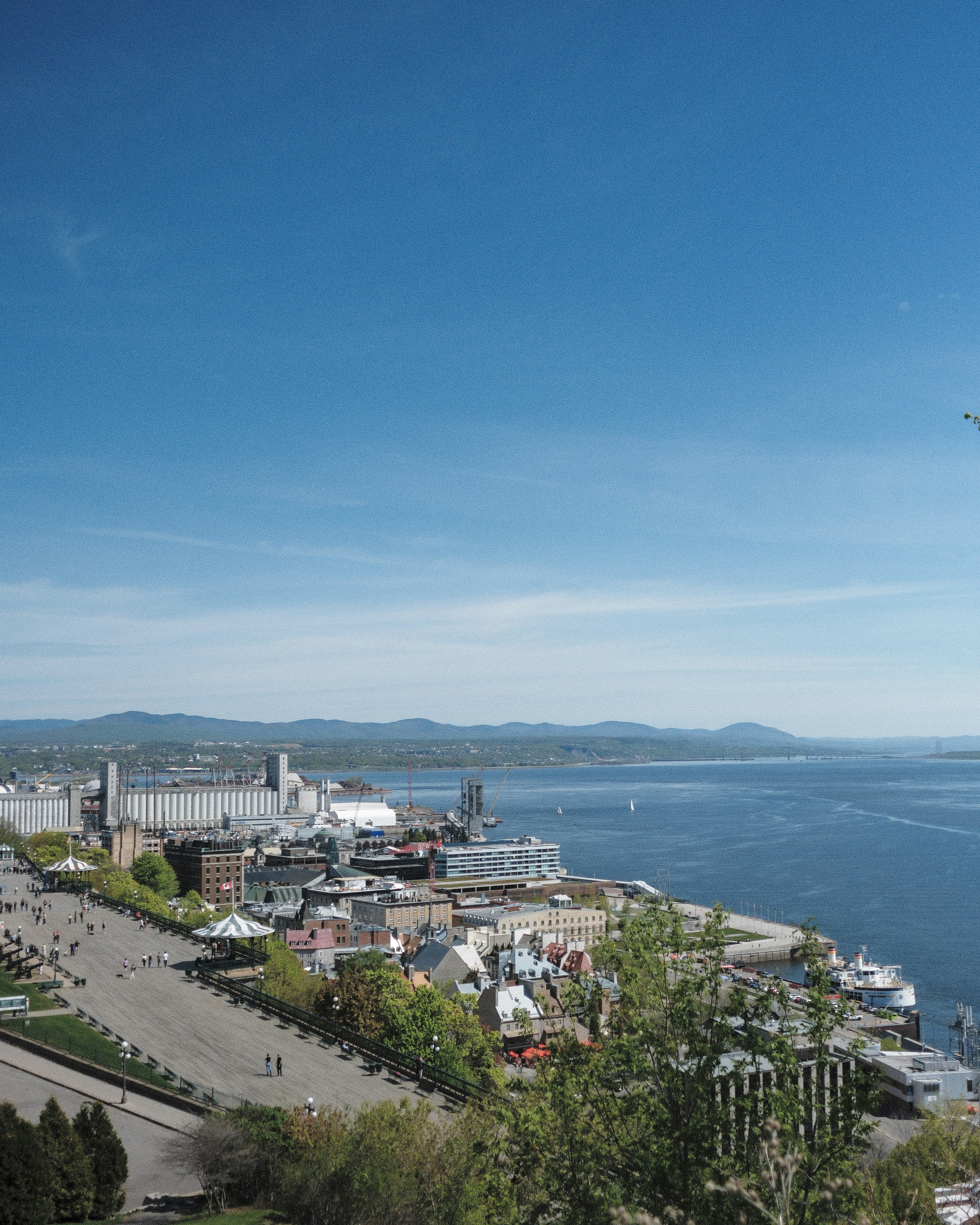 Harborfront Vista: Urban Coastline Under Wide Blue Sky