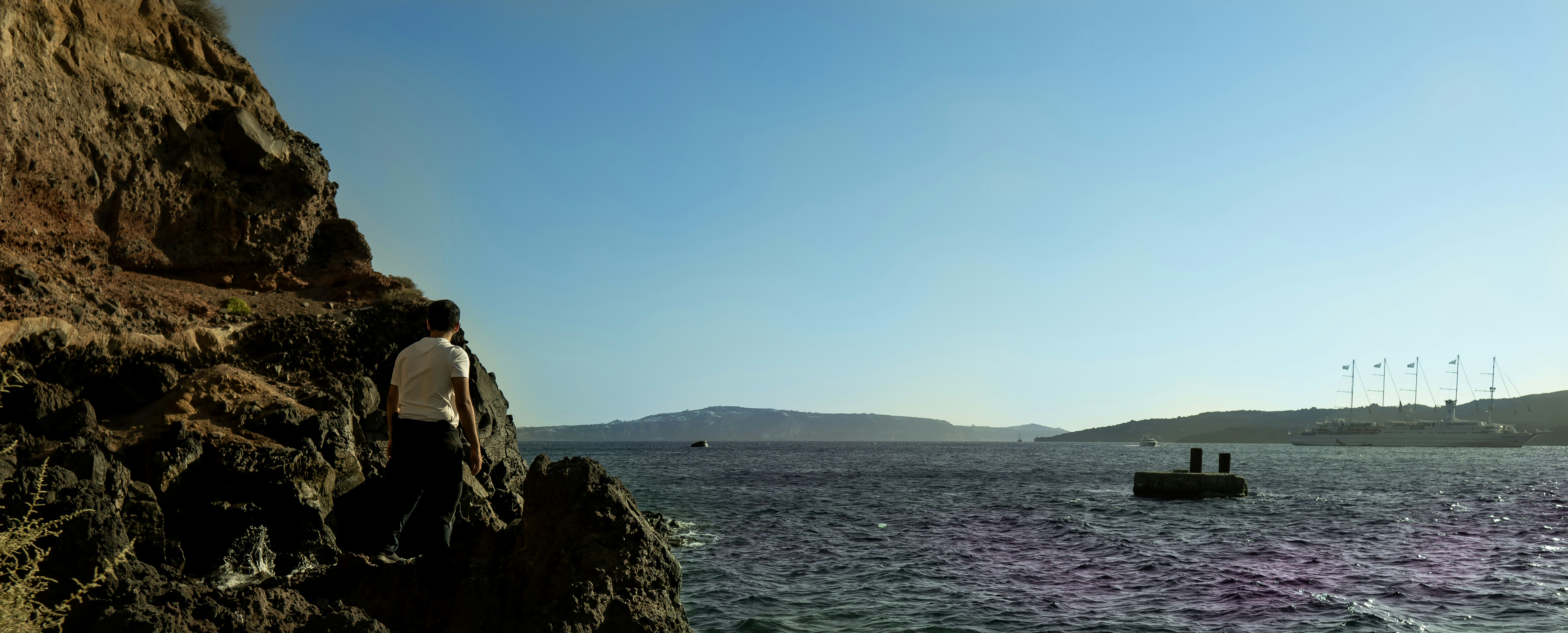 Cliffside Figure Gazes Toward a Distant Harbor