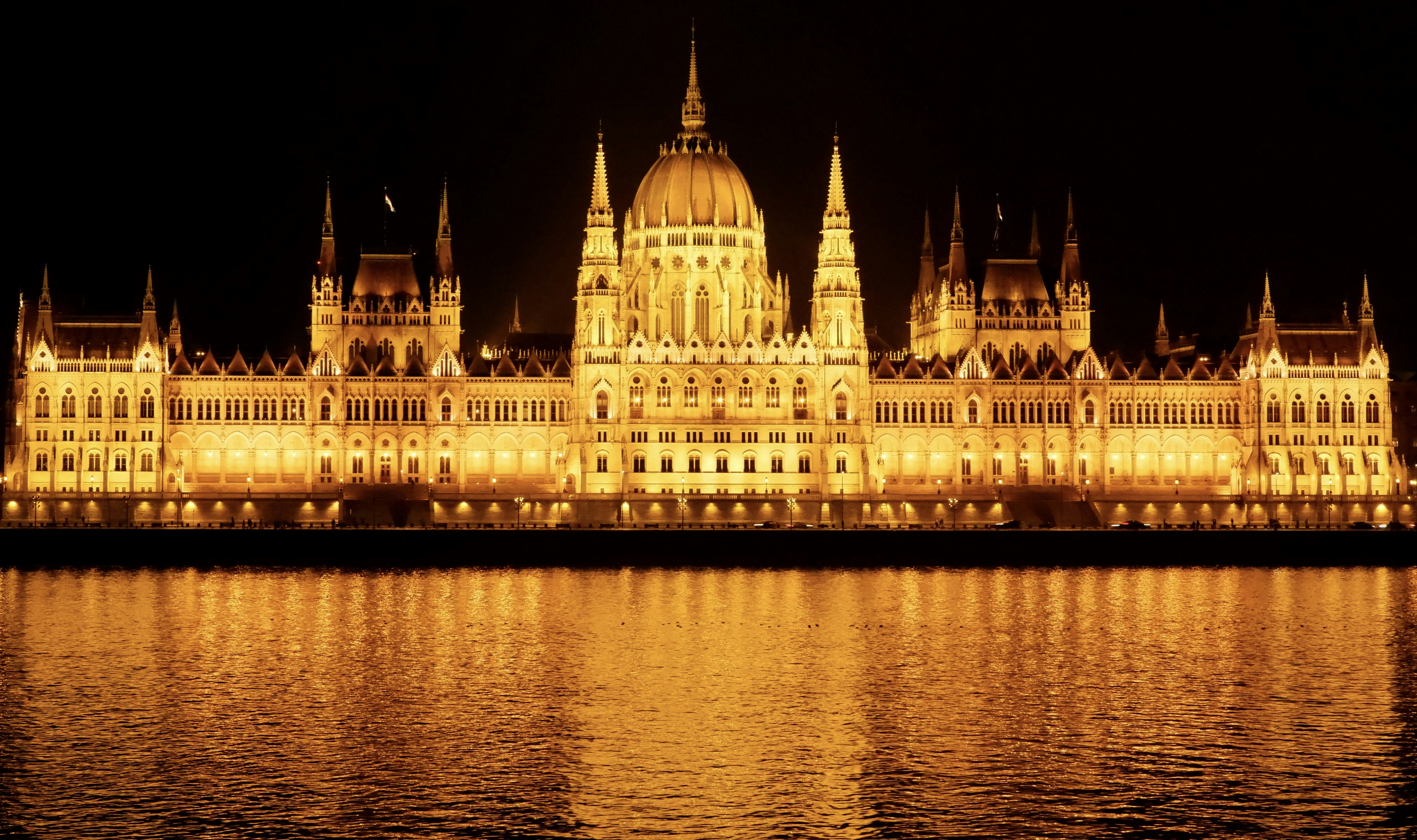 Illuminated Parliament Across Golden Danube at Night