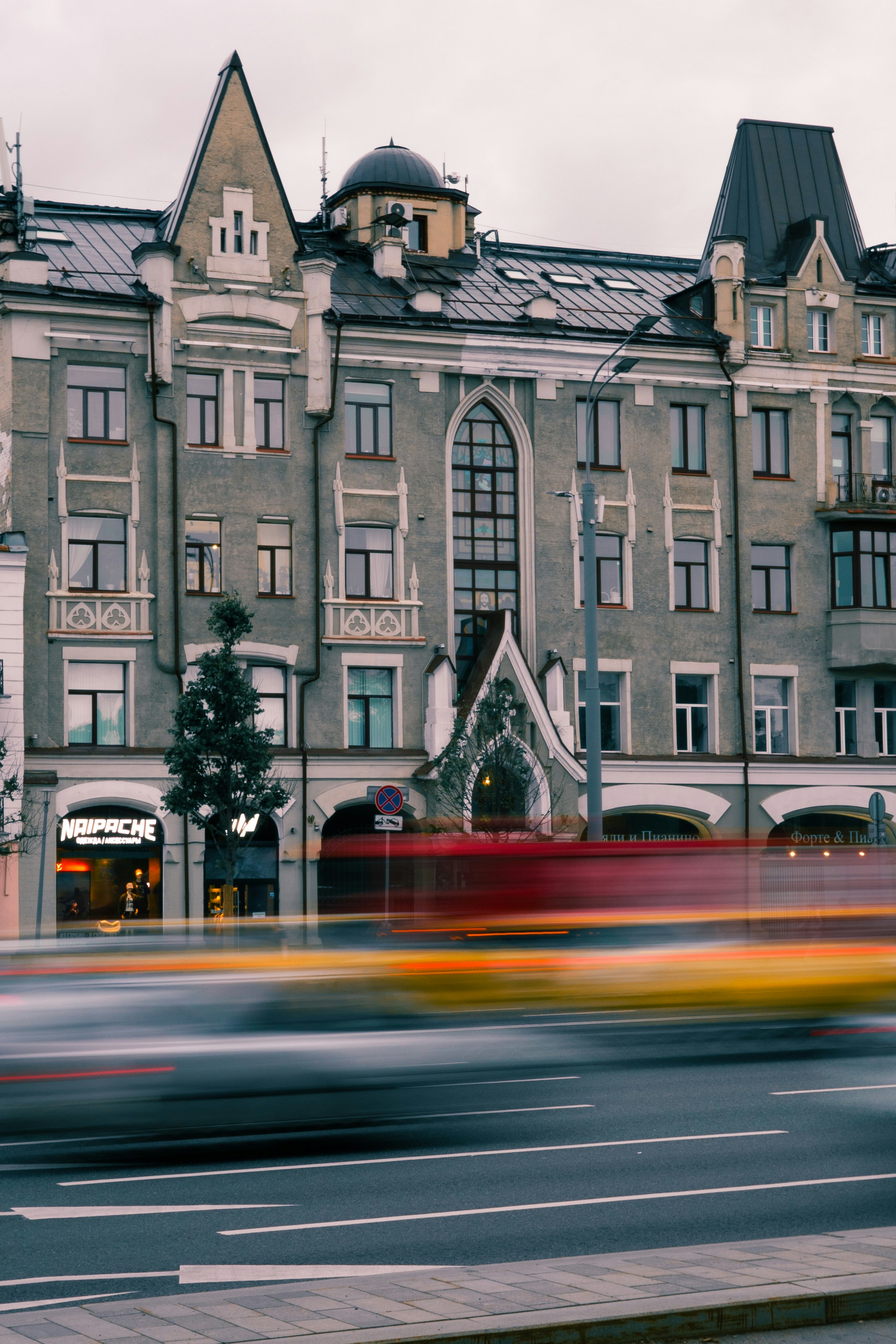 Streaks of City Life Across a Historic Facade