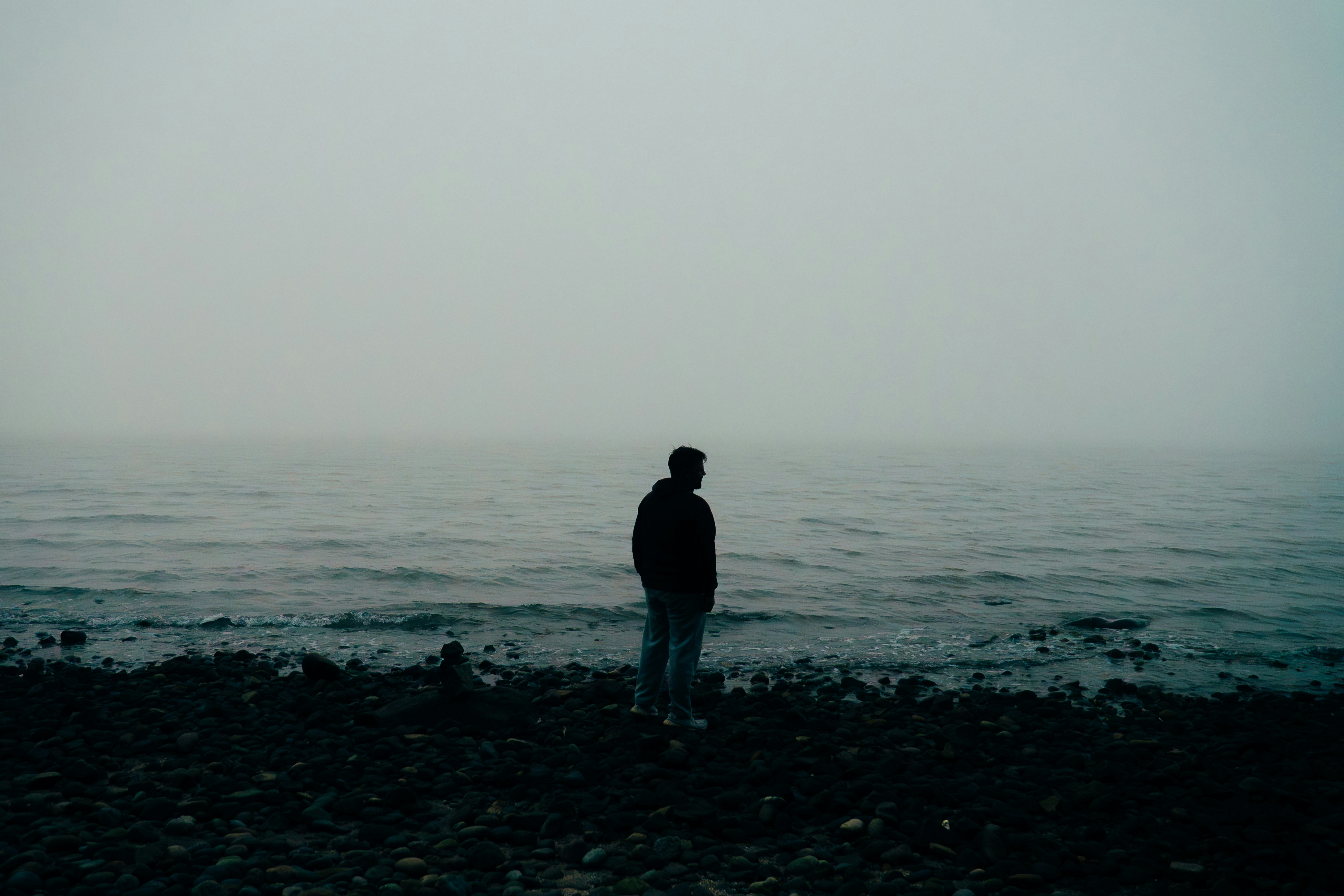 Lone Figure at the Edge of Fogged Seas