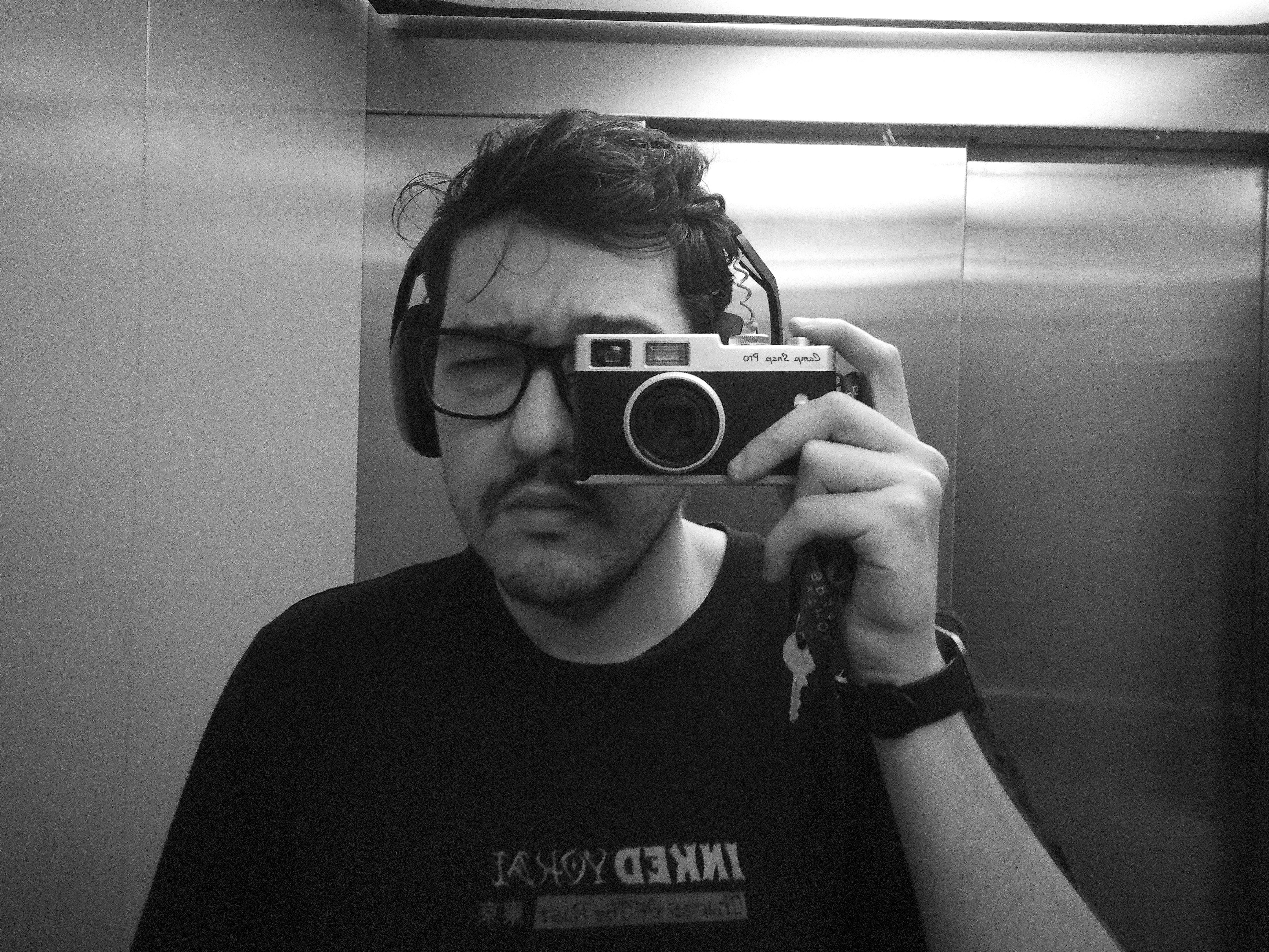 Man taking a mirror selfie with vintage camera.