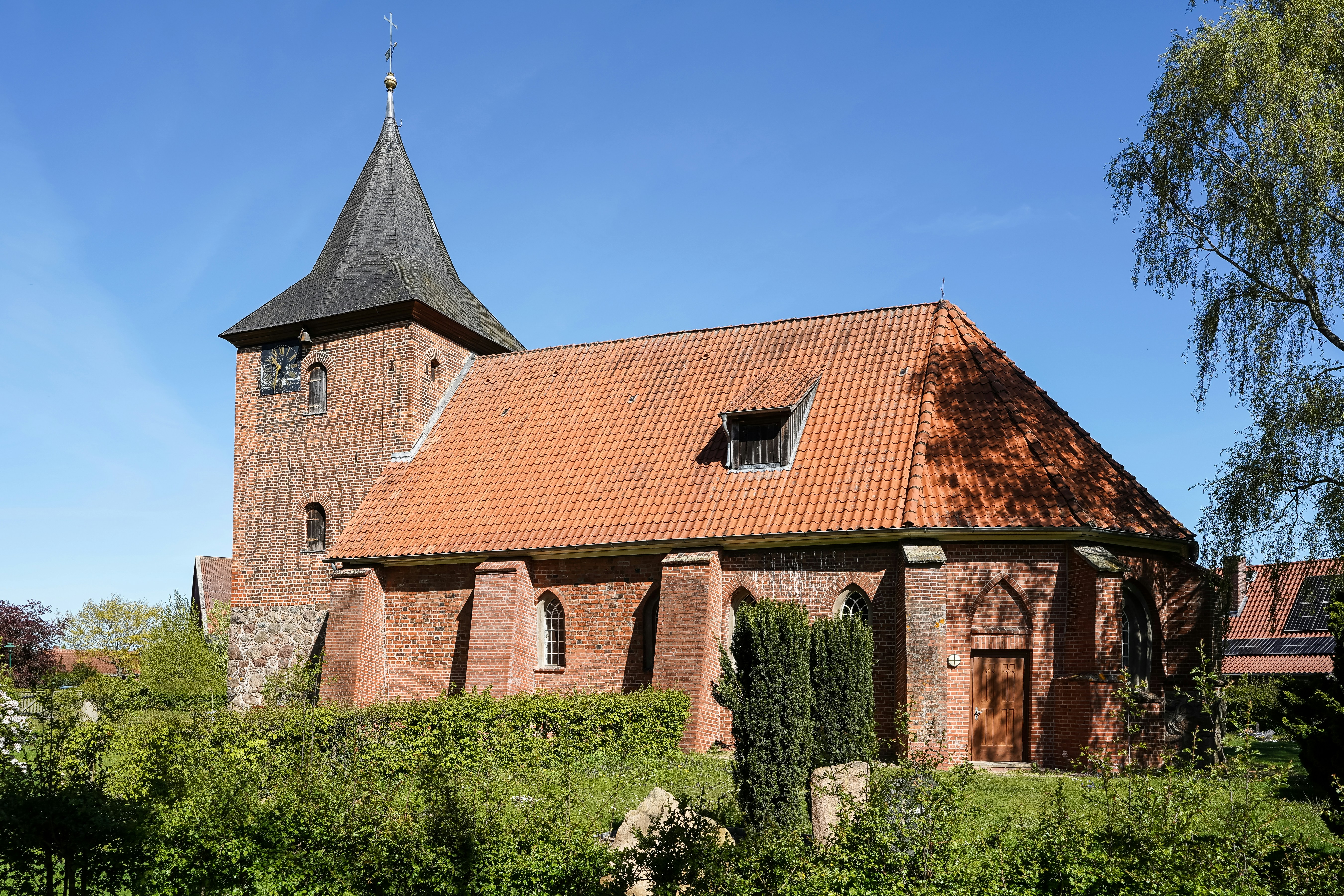 Red-Tiled Chapel Steeple Under a Clear Sky