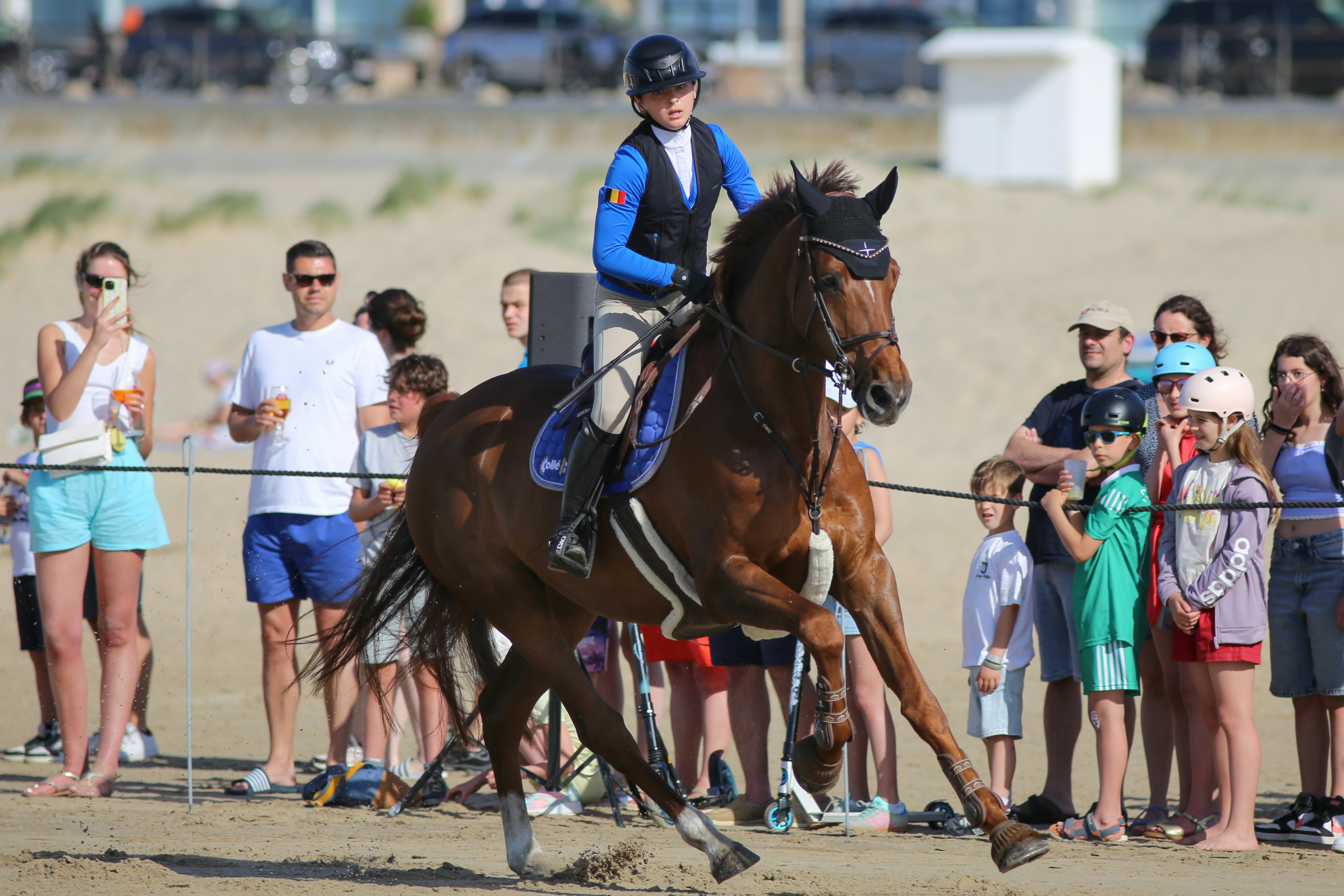 Rider in Blue Leads the Jump Over Sand Arena