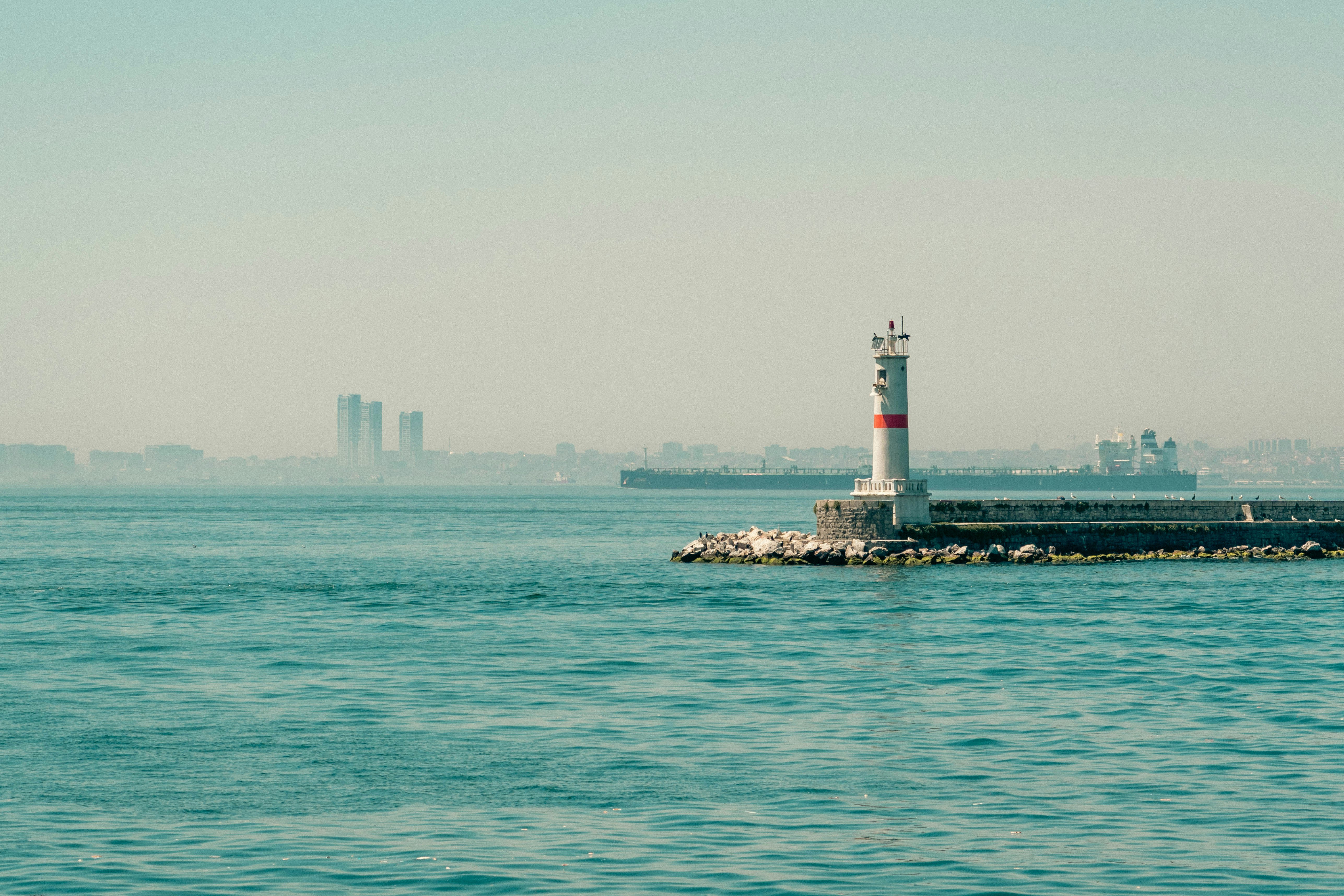 Lighthouse at the Edge: Quiet Harbor Under a Misty Horizon