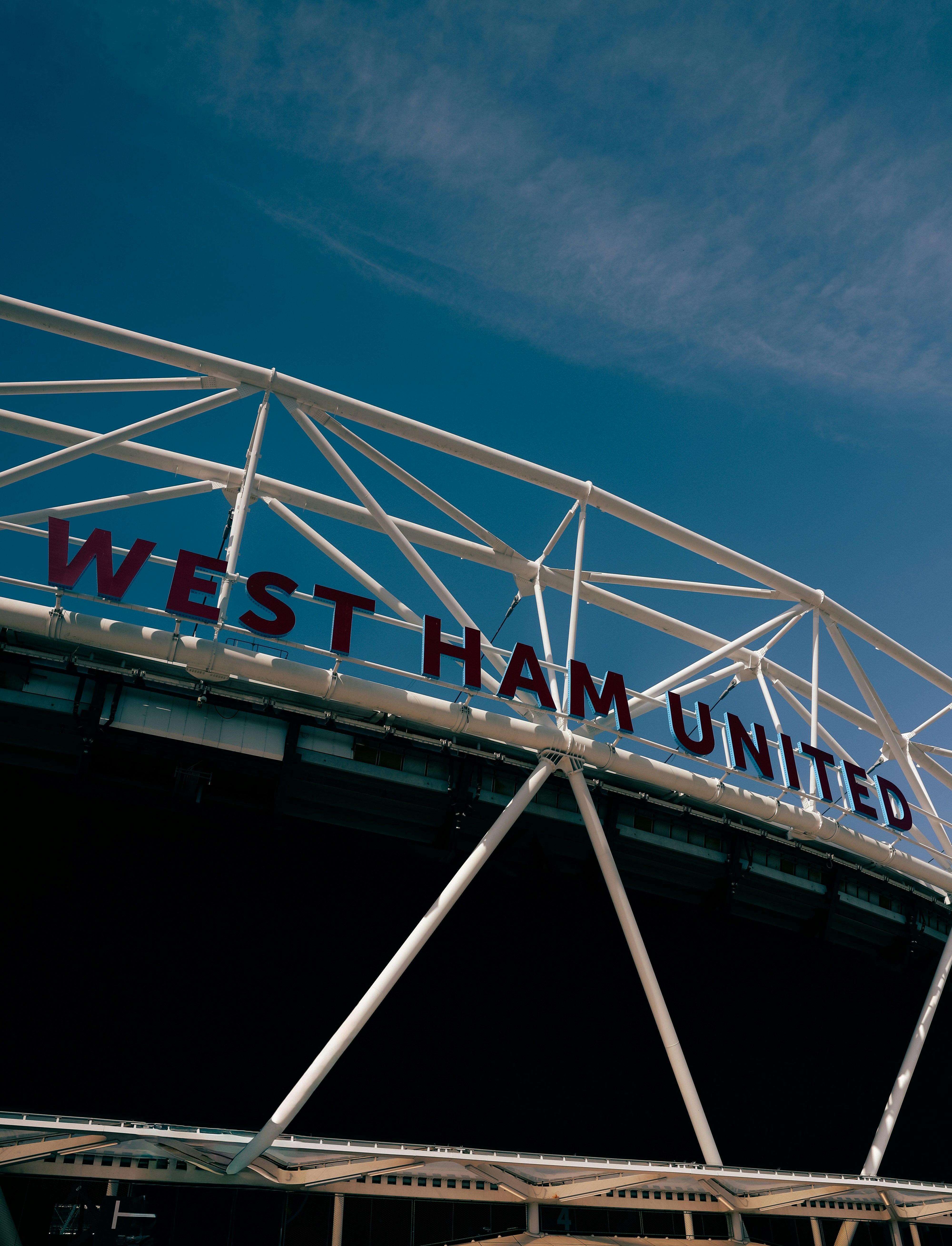 West ham united stadium sign against a clear blue sky.