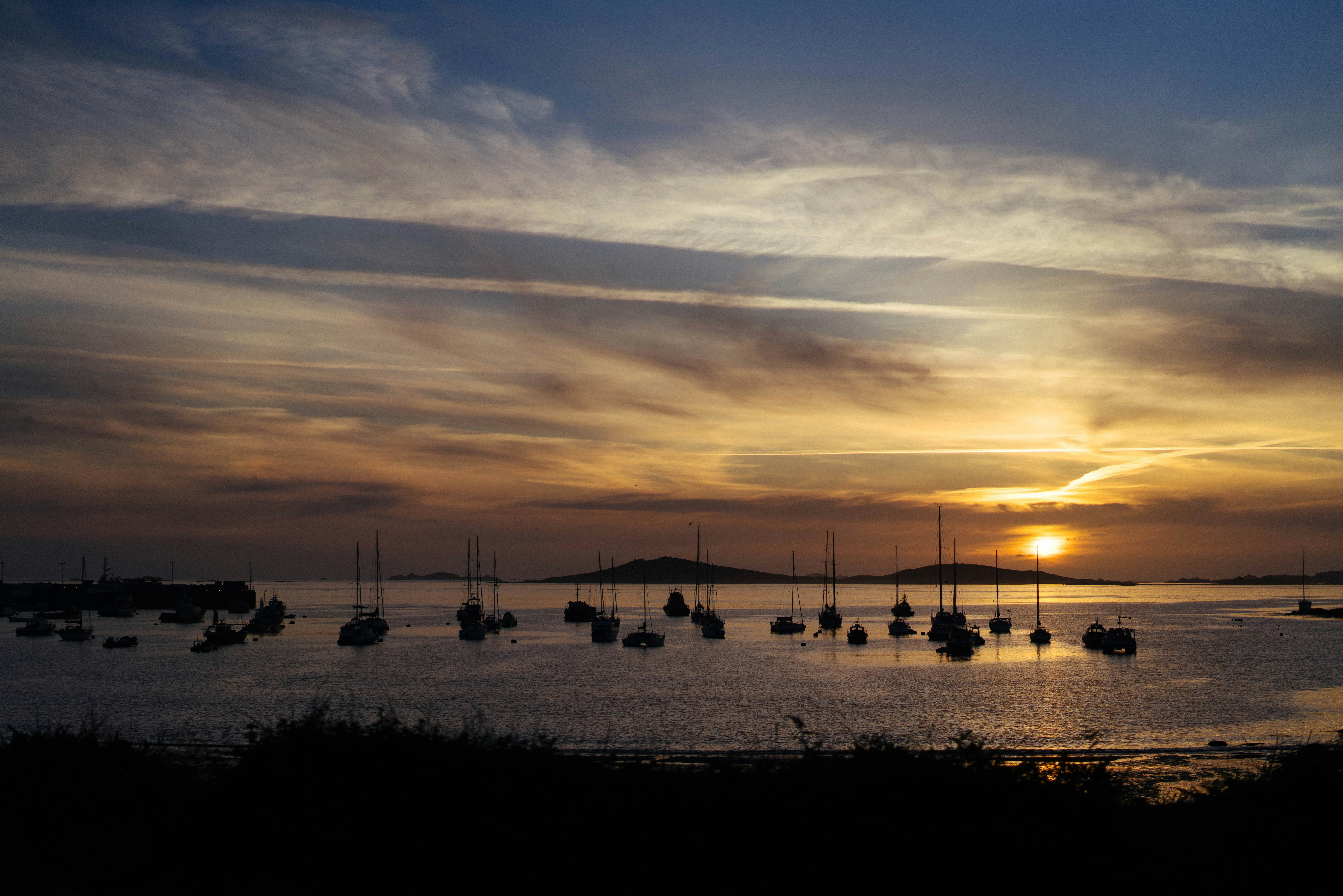 Sunlit Marina at Dusk: Boats Rest Beneath a Golden Horizon