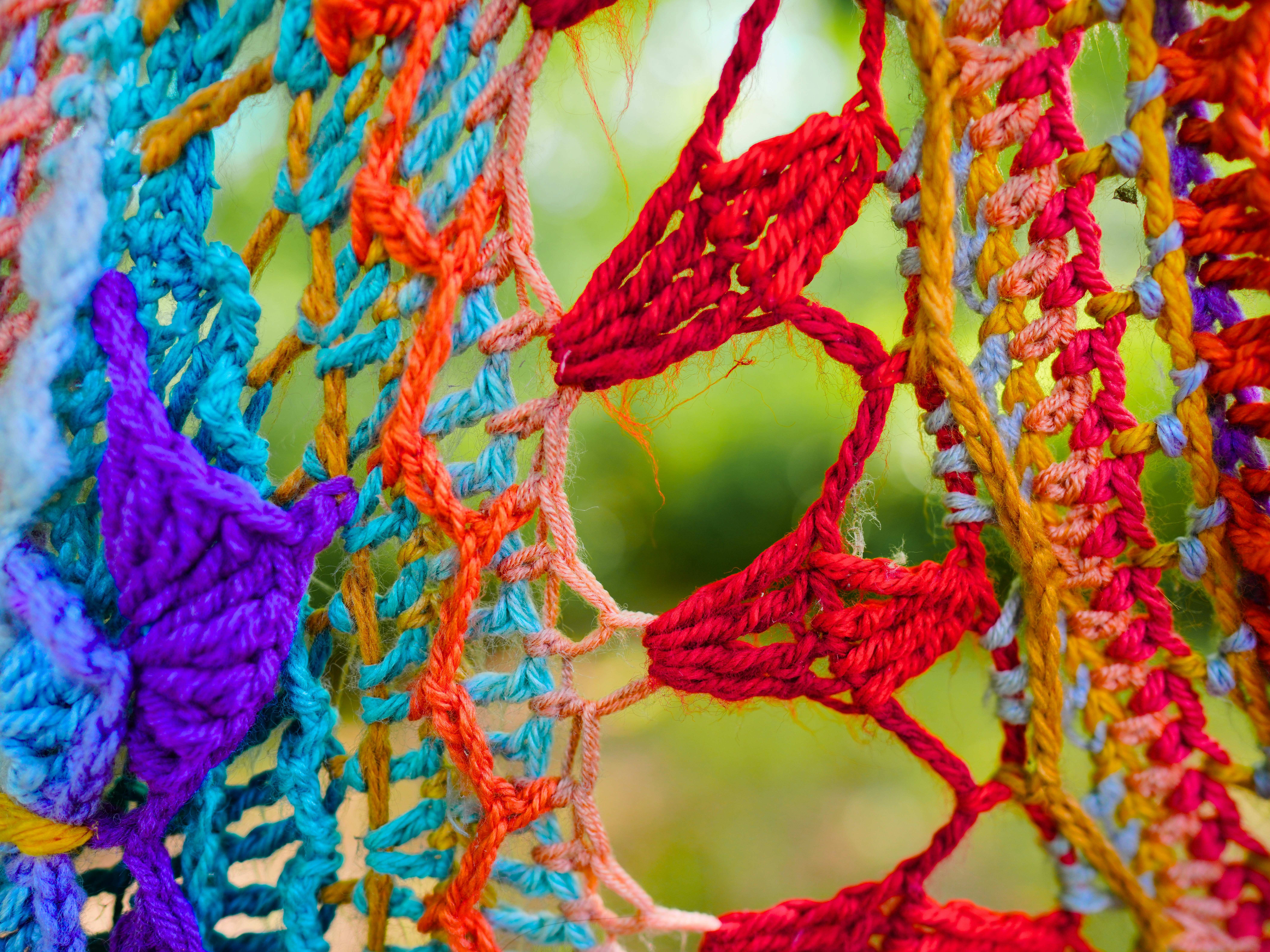Threads in Bloom: a vivid tangle of knitted color against a soft green bokeh