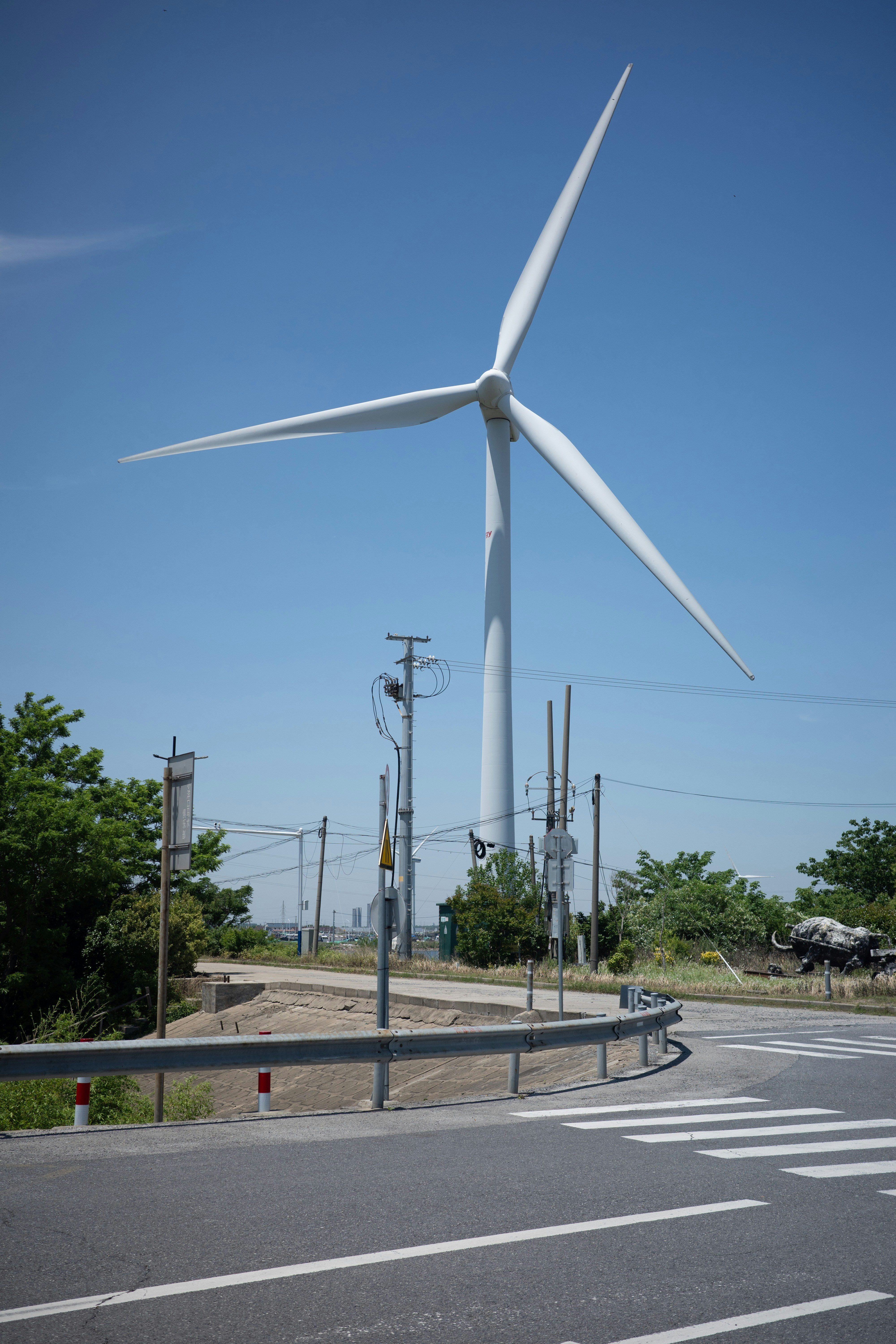 Giant Windmill Stands Tall Over Coastal Road