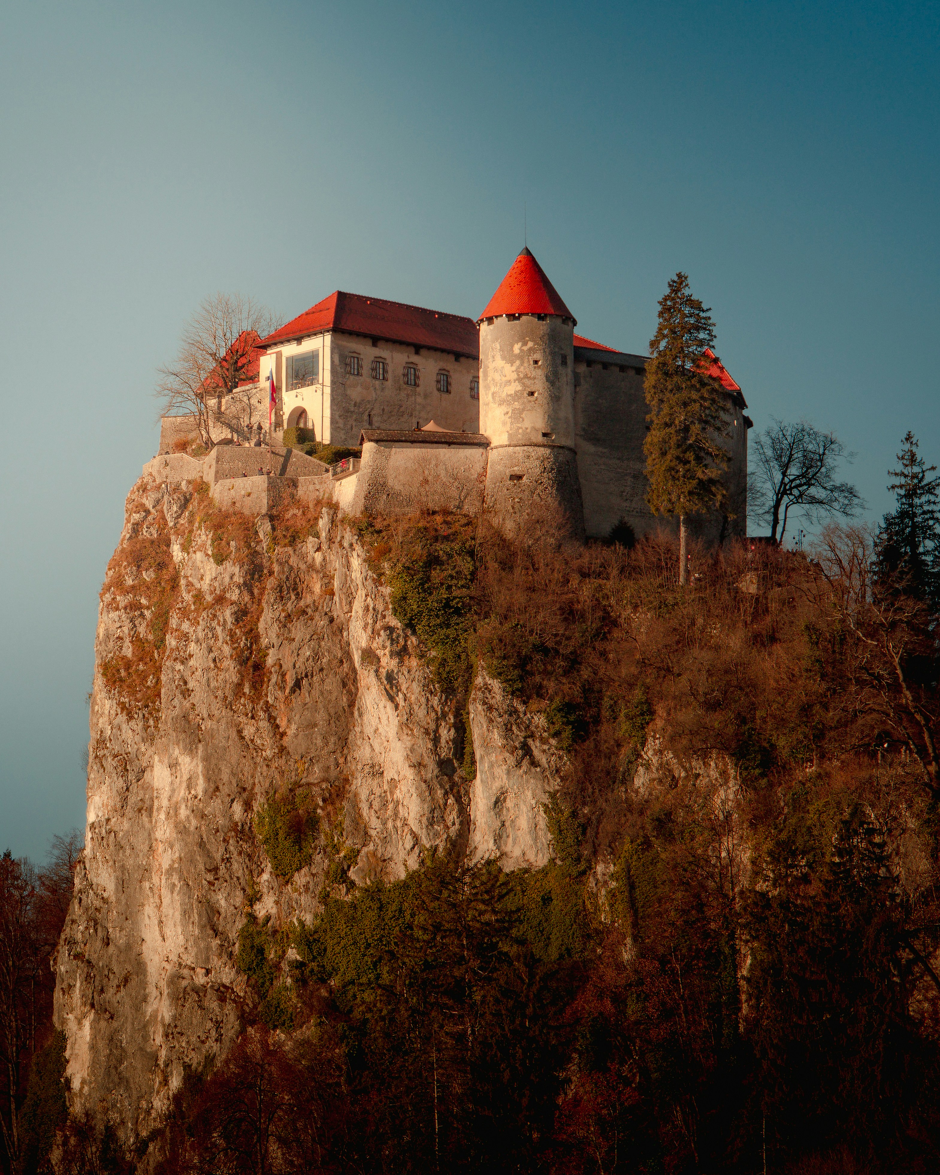 Castle on the Cliff: A Red-Topped Stronghold Brimming with Autumn Light
