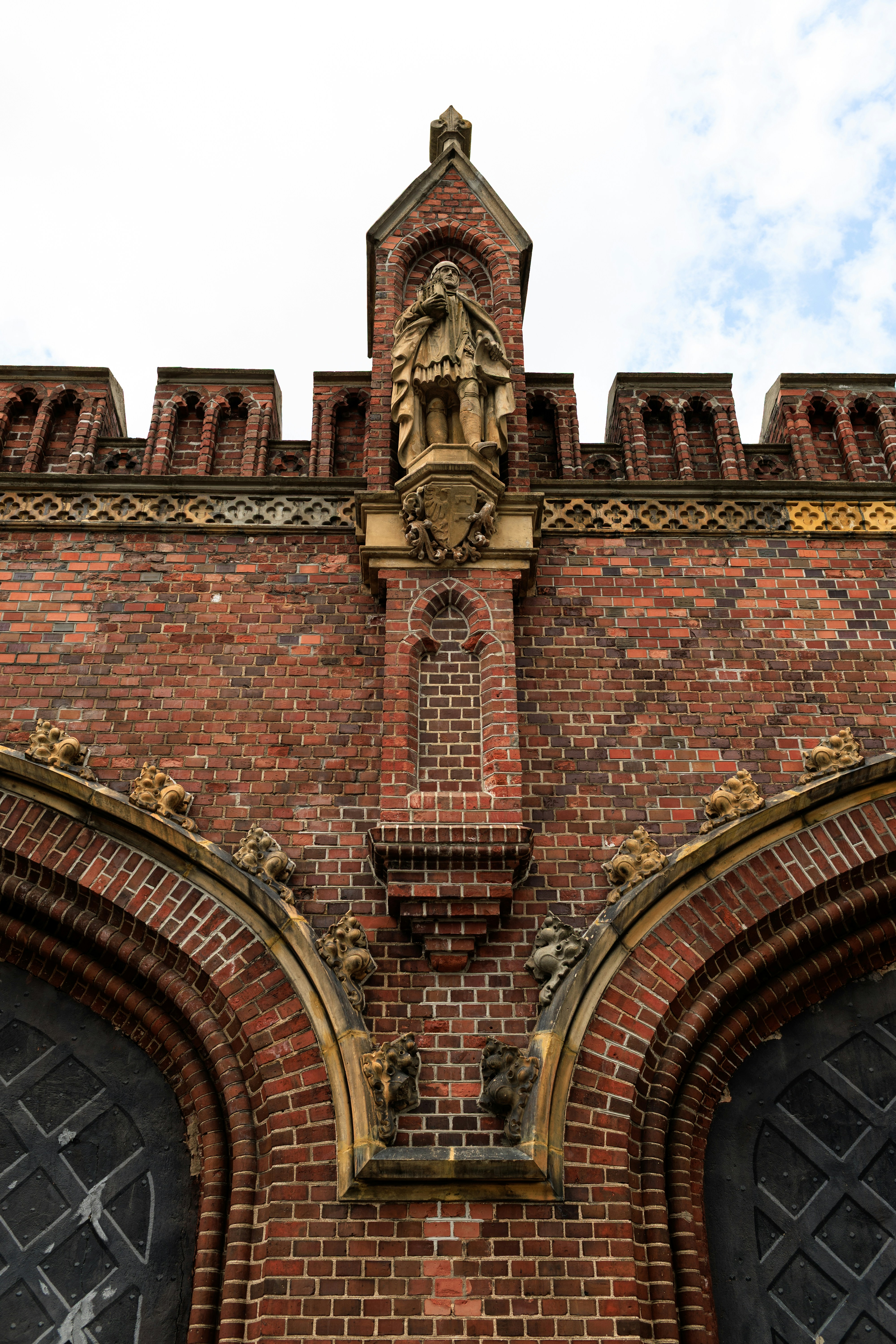 Statue Crowned by Brick Gothic Facade Devotion