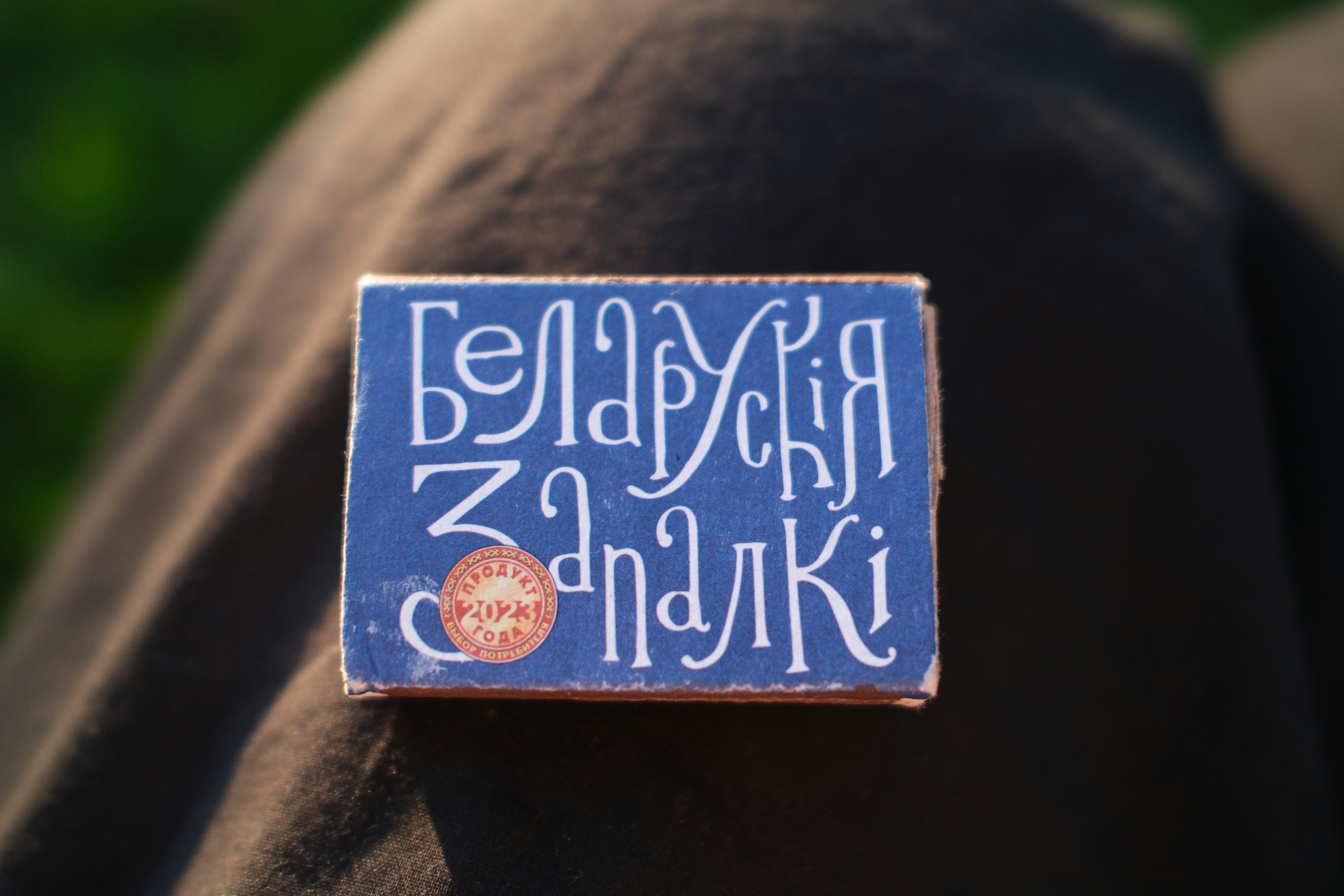 Blue Russian Card Box resting on dark lap in sunlight