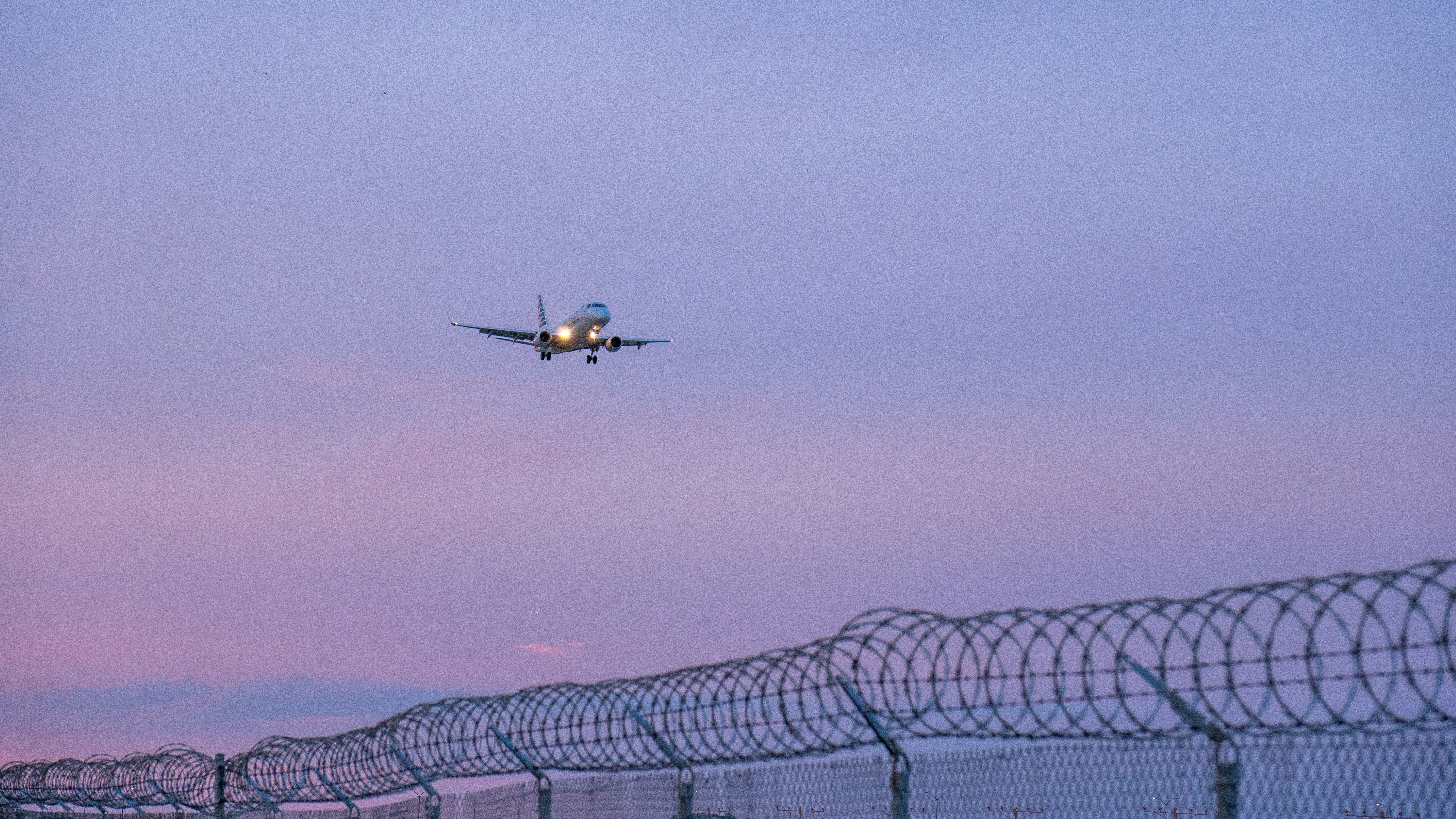 Approach in Pink: A Narrow-Body Passes Over a Barbed Horizon