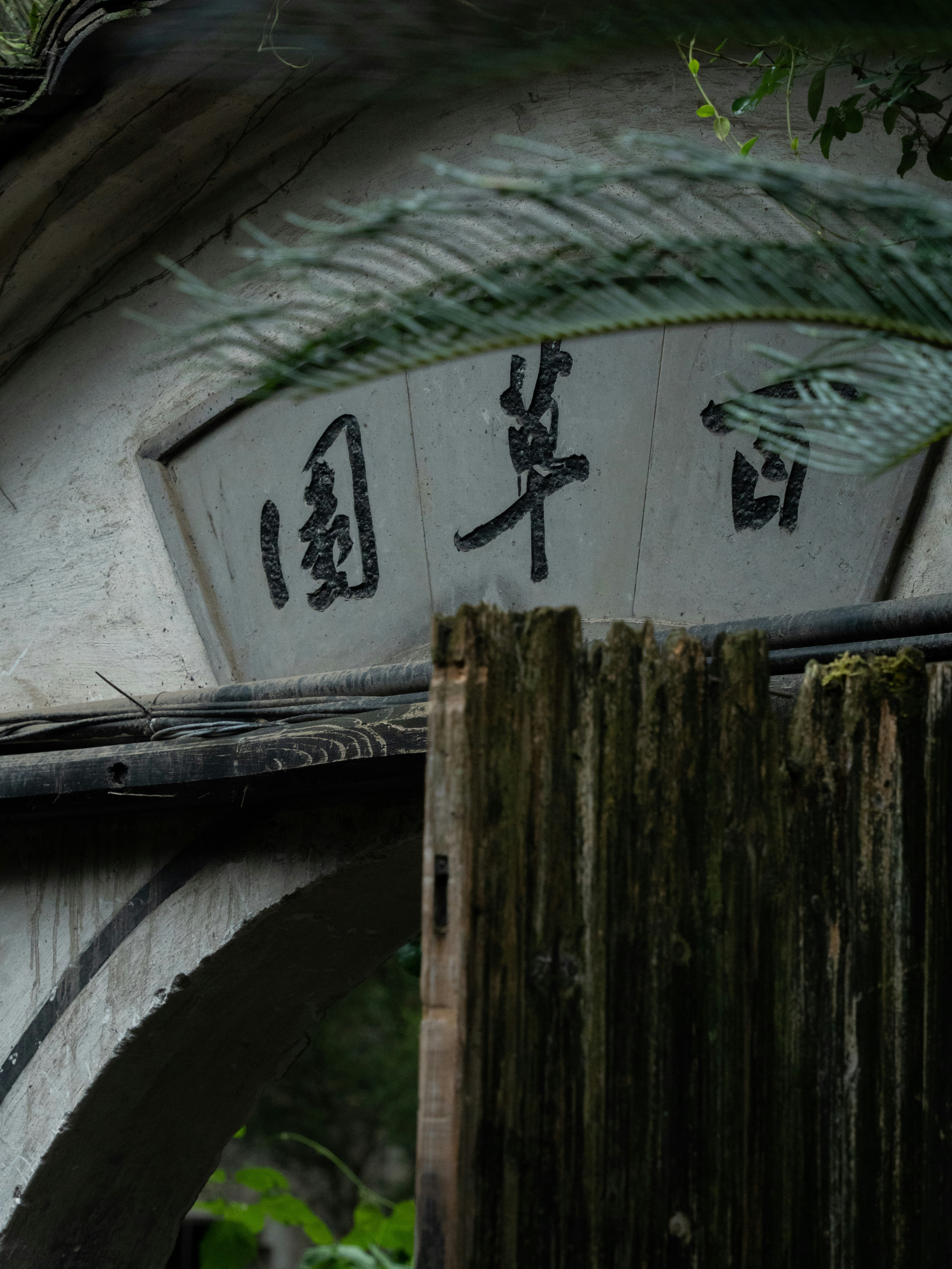 Mist over the Arch: Weathered Stone, Moss-Capped Fence