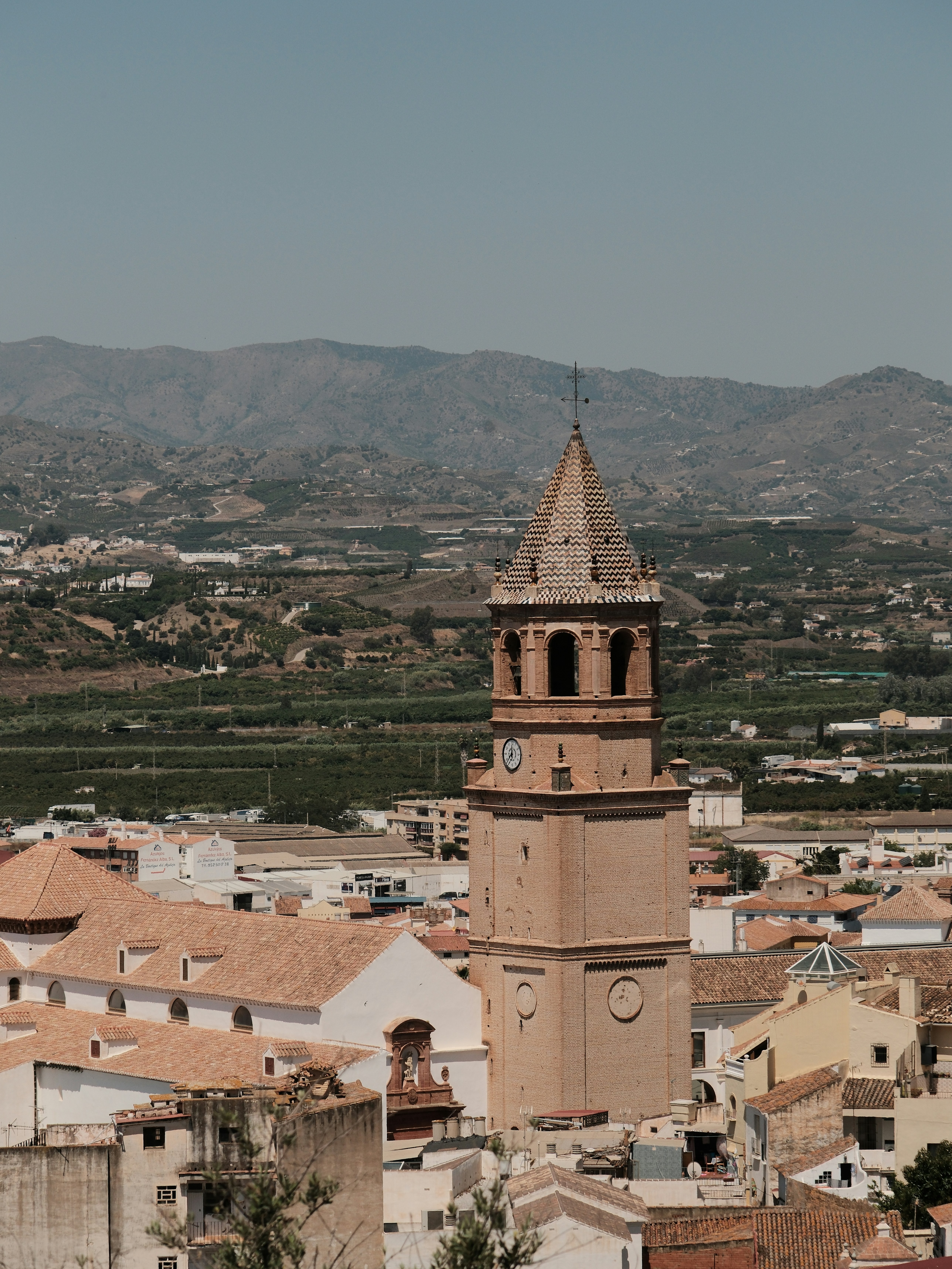 Towering Clock Tower Amid Rustic Village Panorama