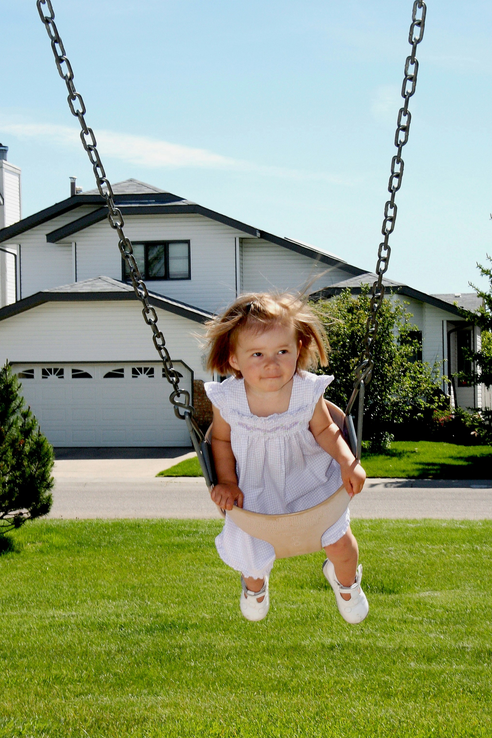 Child on a Swing Bubbles with a Suburban Backdrop