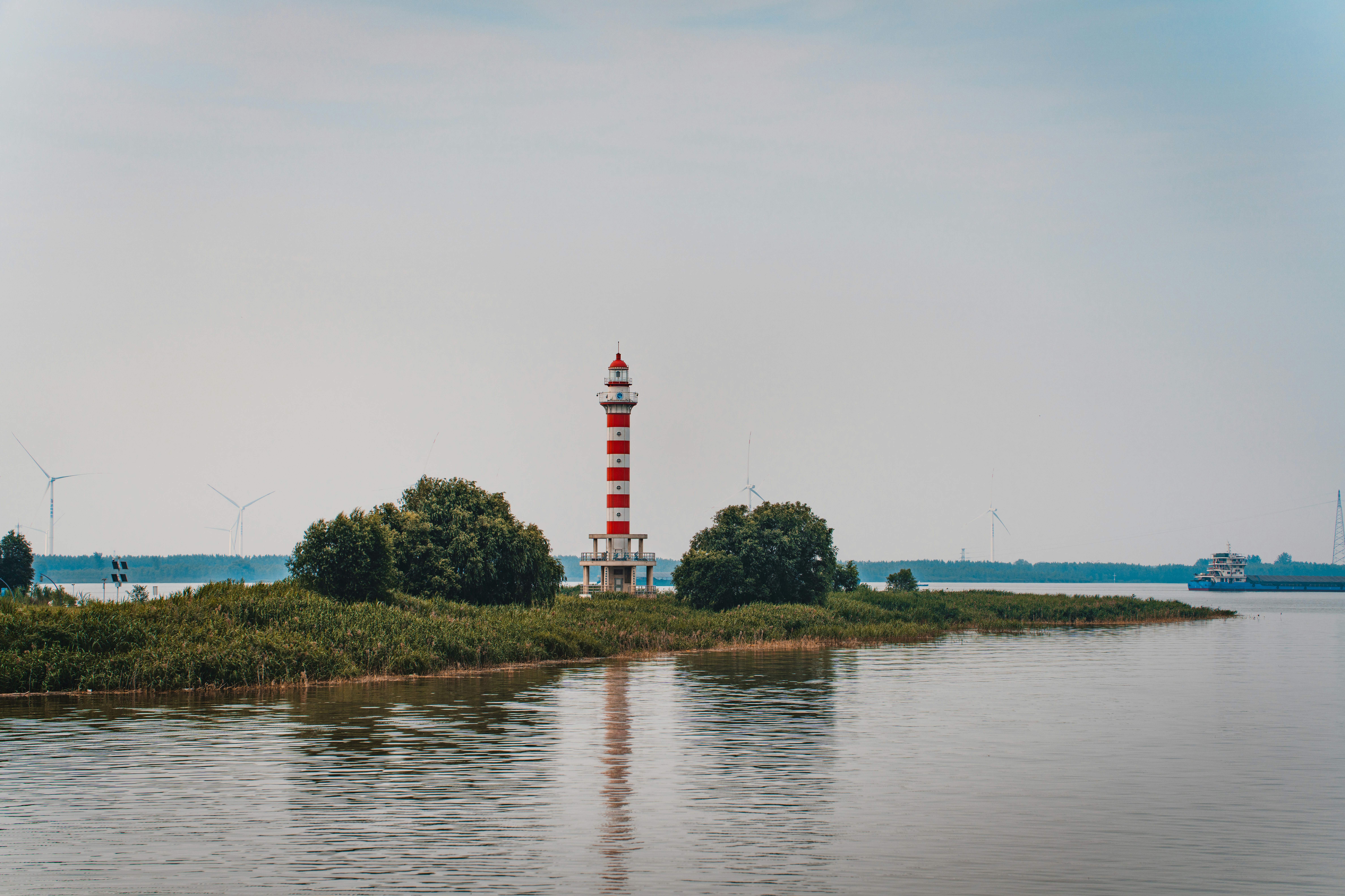 Lighthouse Sentinel: Red-and-White Beacon over Quiet Tidelands