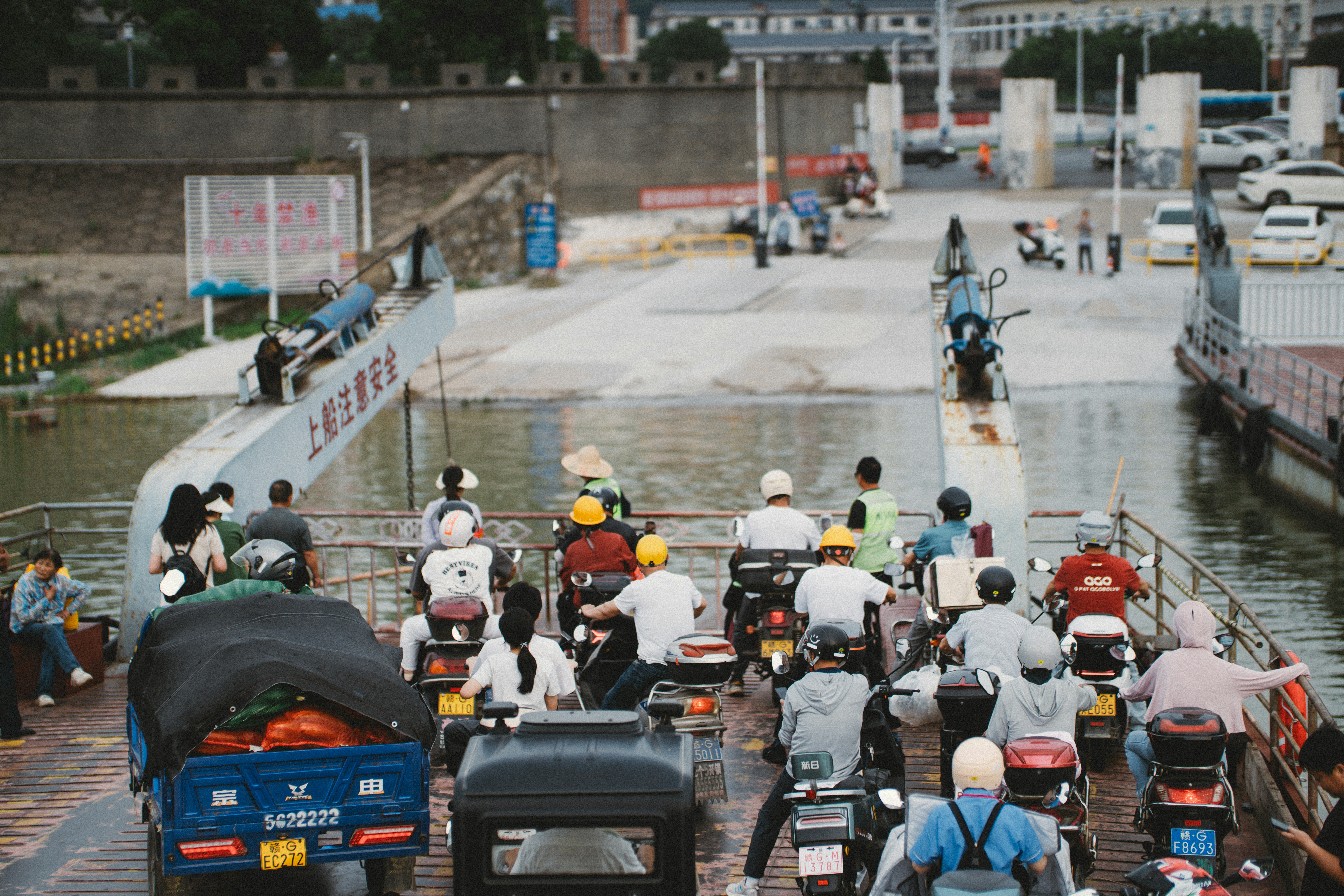 Queue on the Ferry: A Riverside Crossing of Scooters and Small Cars