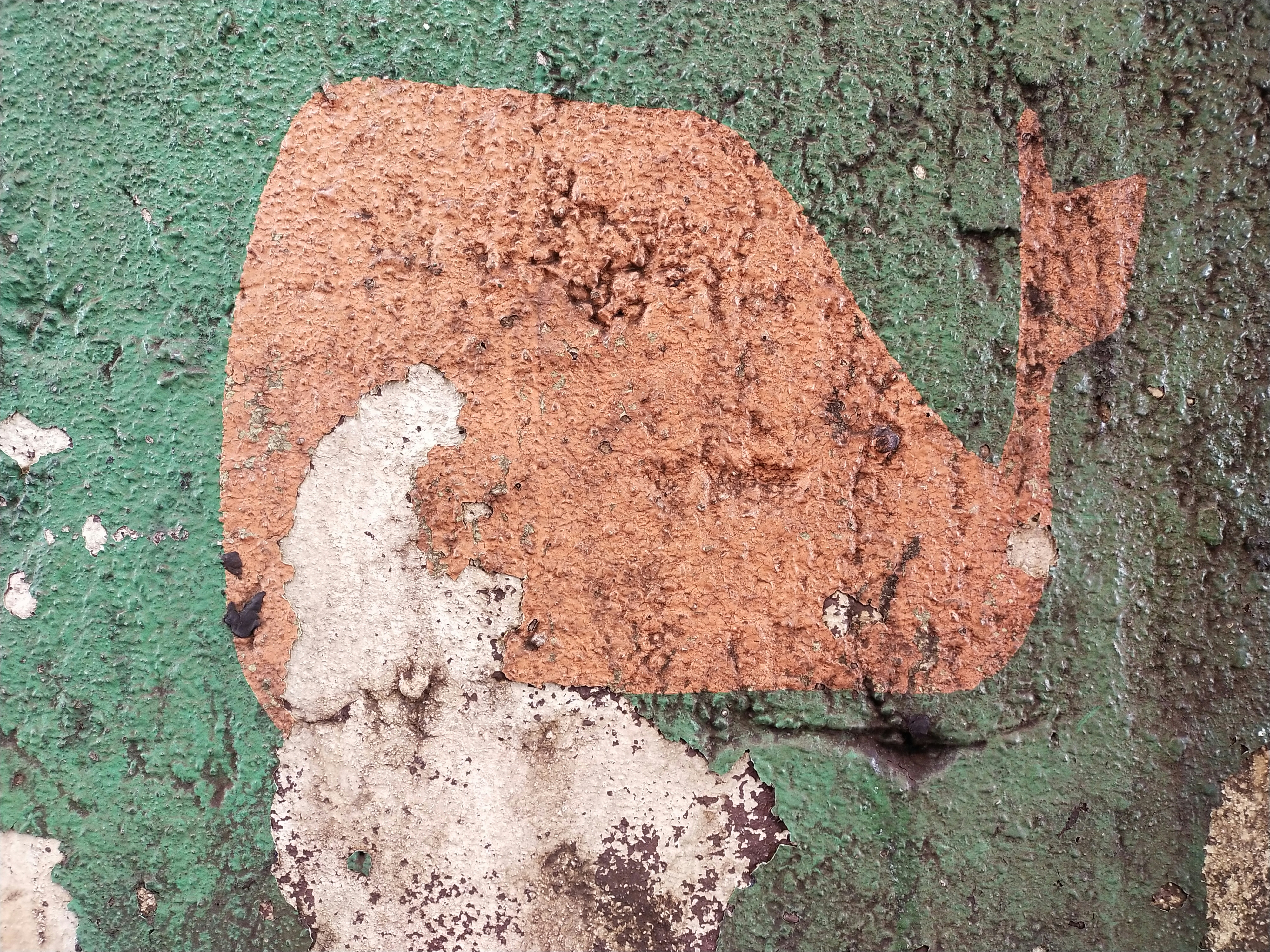 Peeling Orange Icon on Weathered Green Wall