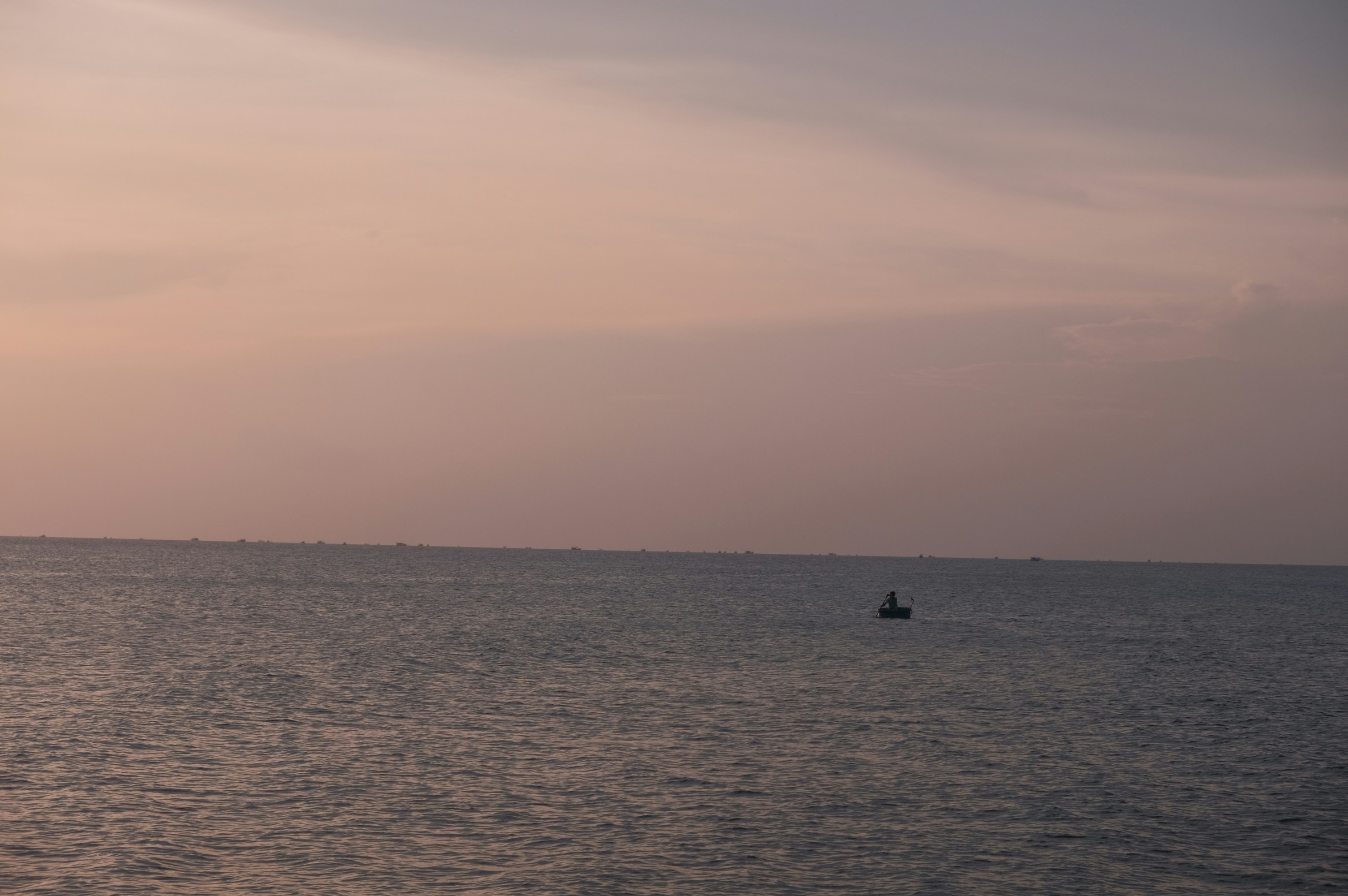 Silent Vessel at Dusk: A lone boat on calm seas