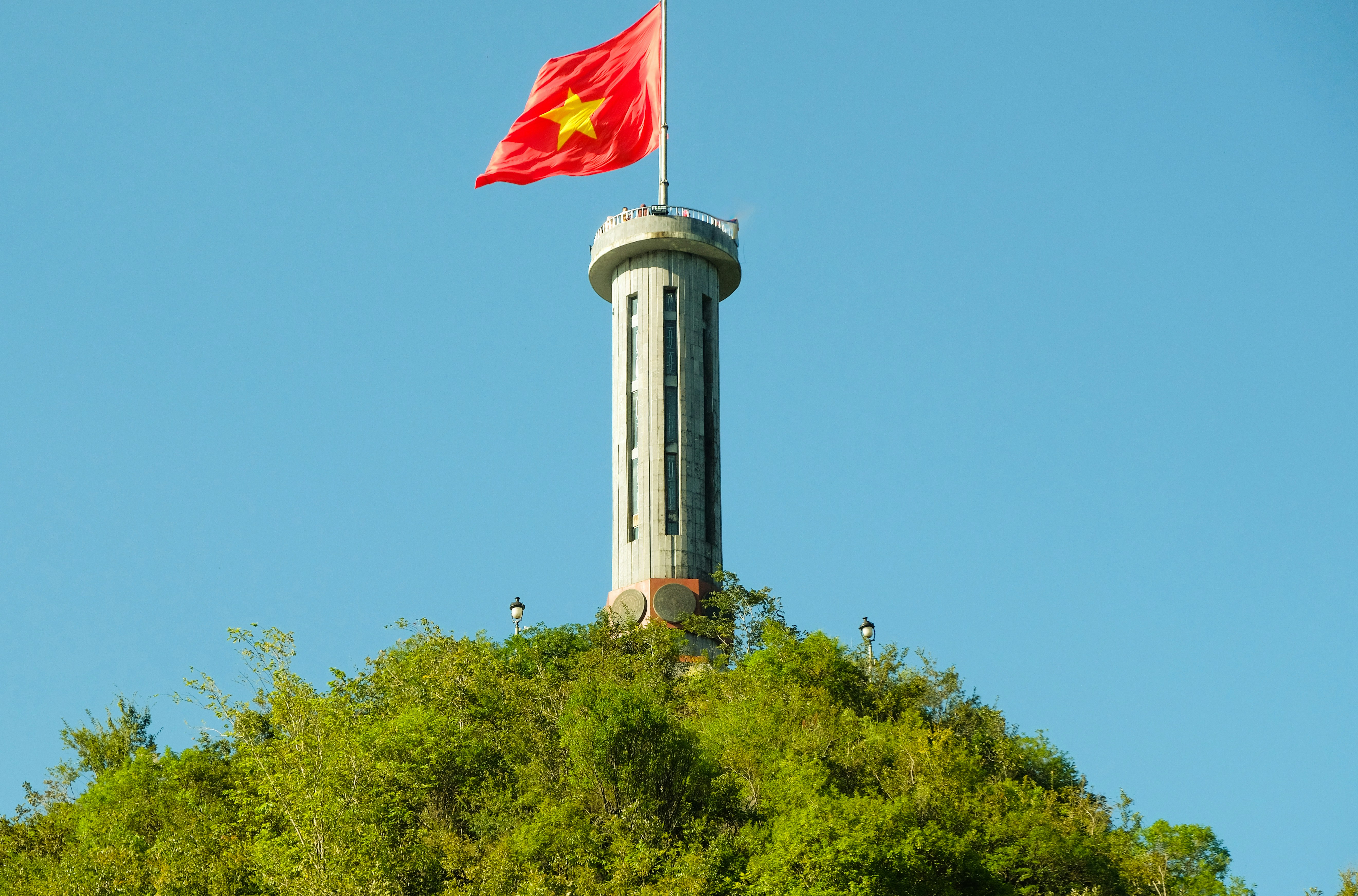 Flag atop a hillwatch: the Chinese flag over a cylindrical monument
