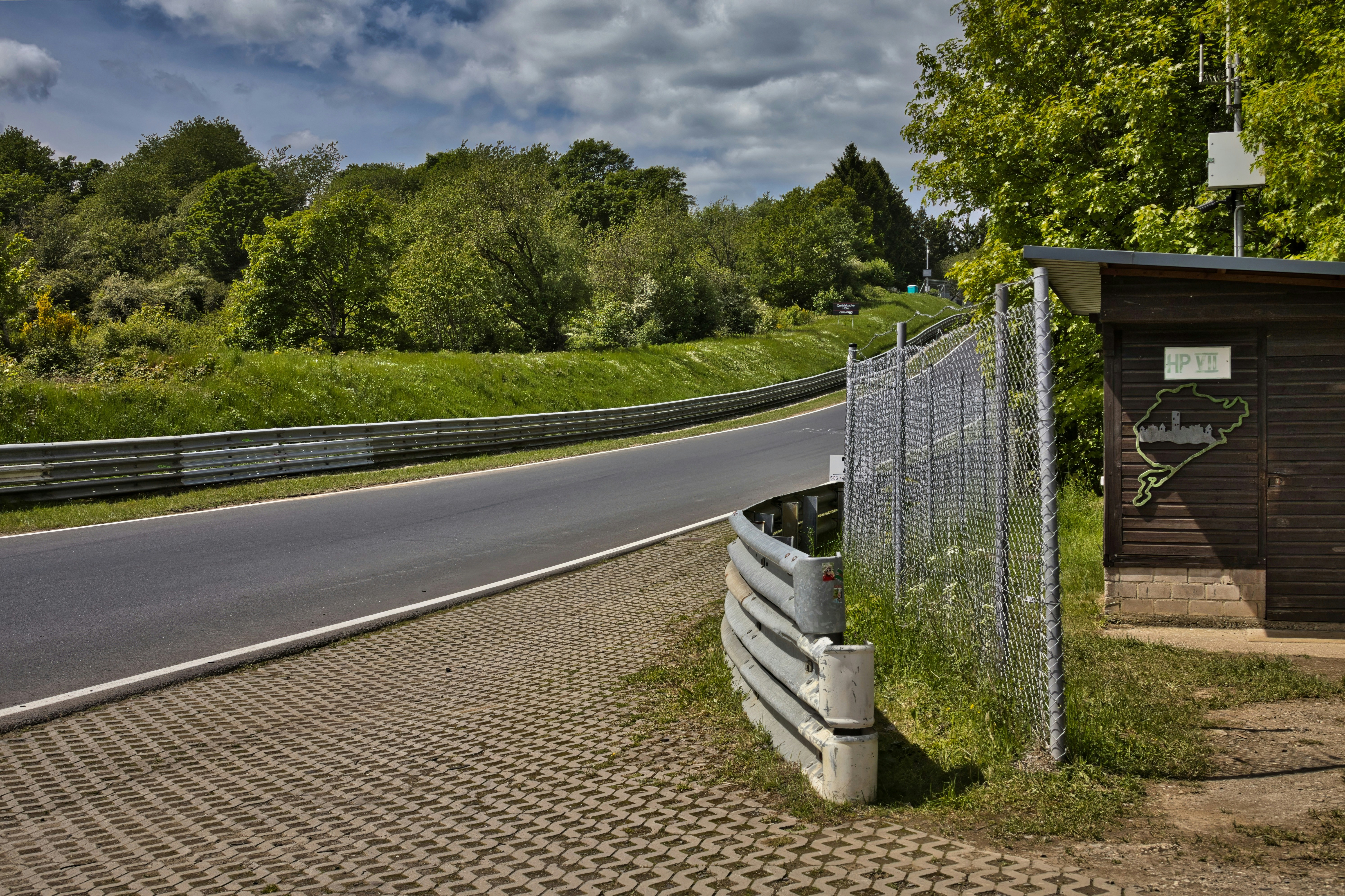 Guarded Curve: Fence, Shelter, and Quiet Roadside