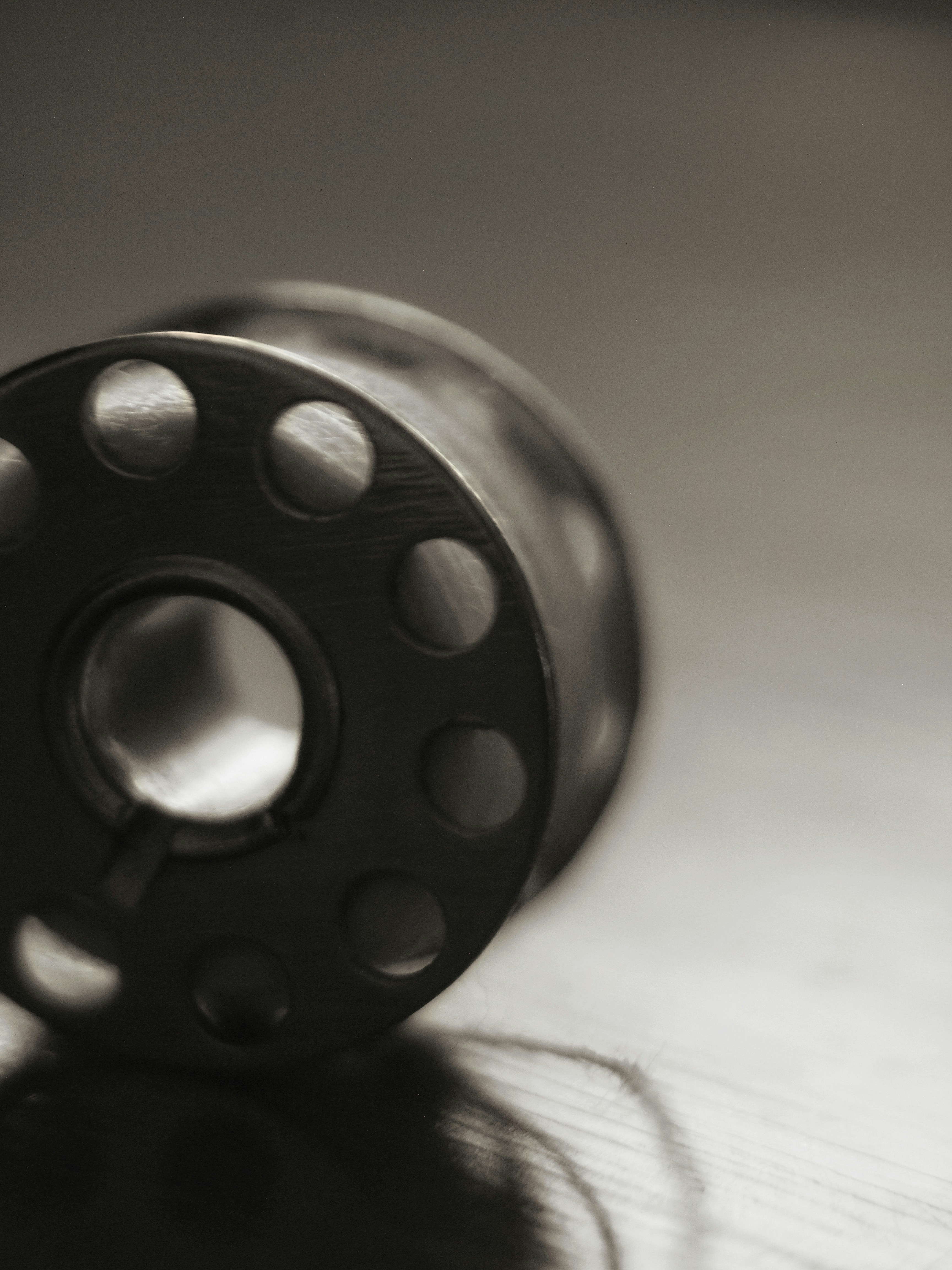 Macro shutter: close-up of a camera reel sprocket on a wooden surface