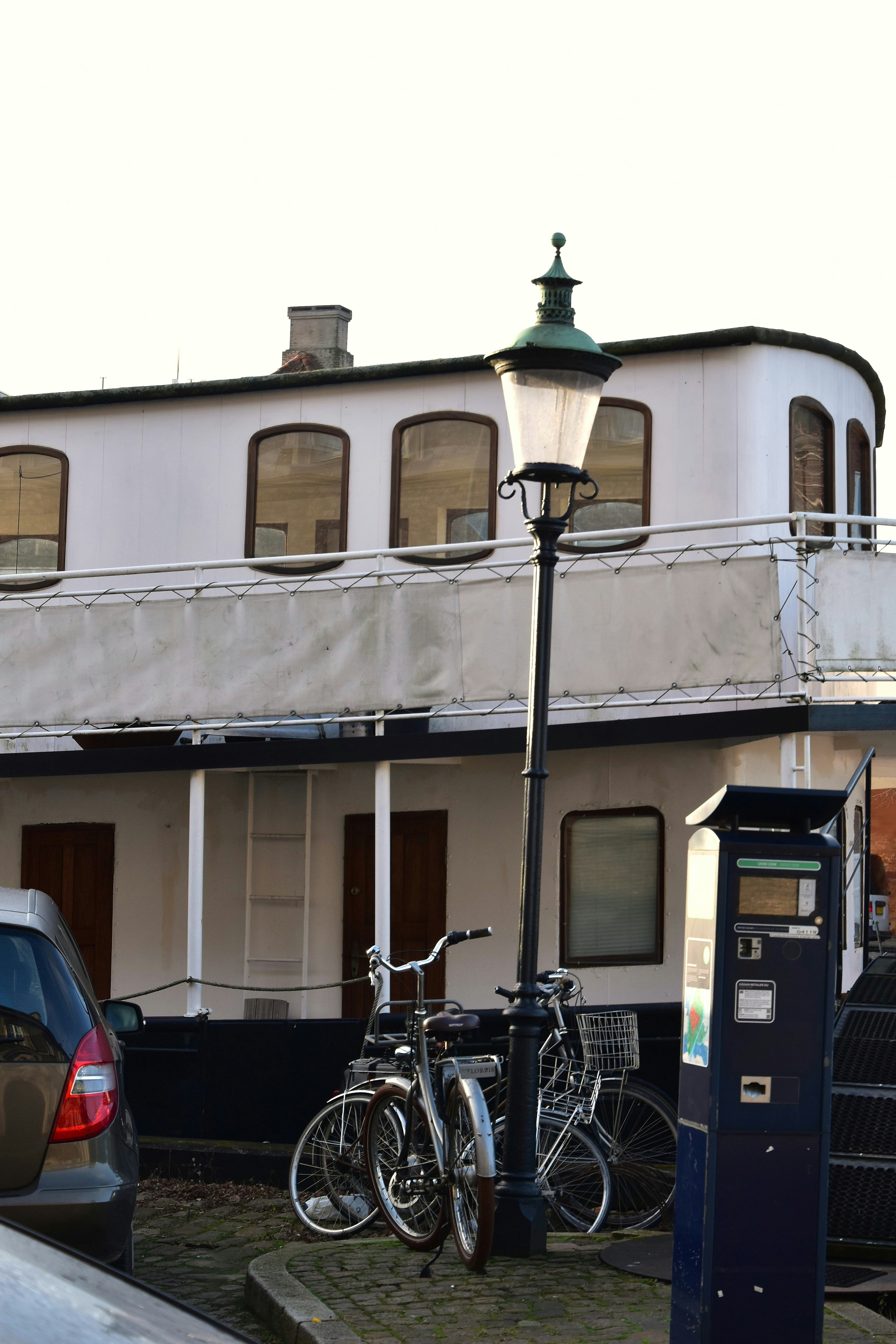Harborfront Terrace: Bikes, Lamp, and a Quiet Street Scene