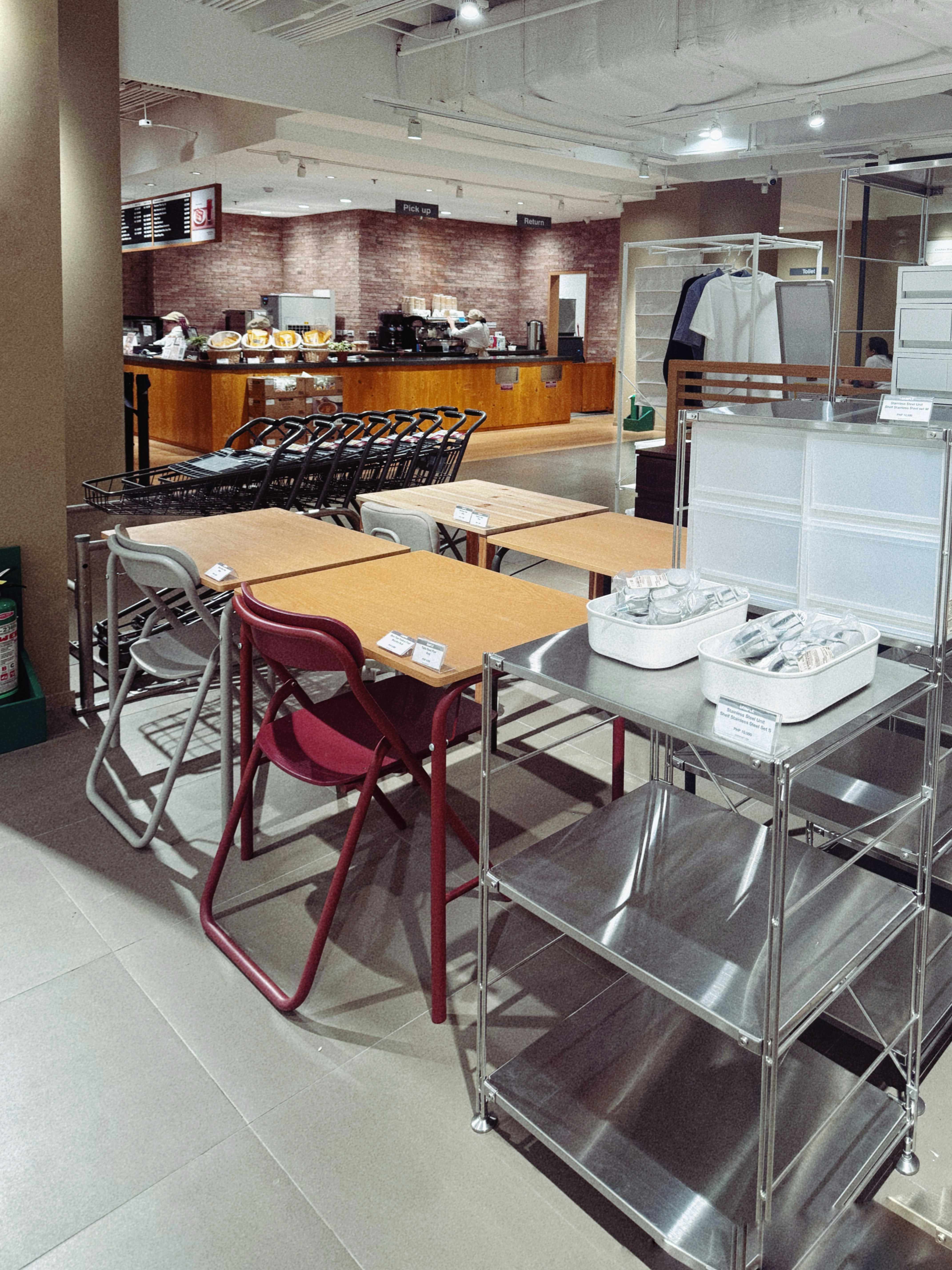 Modern store interior with cafe seating and stainless steel shelves.