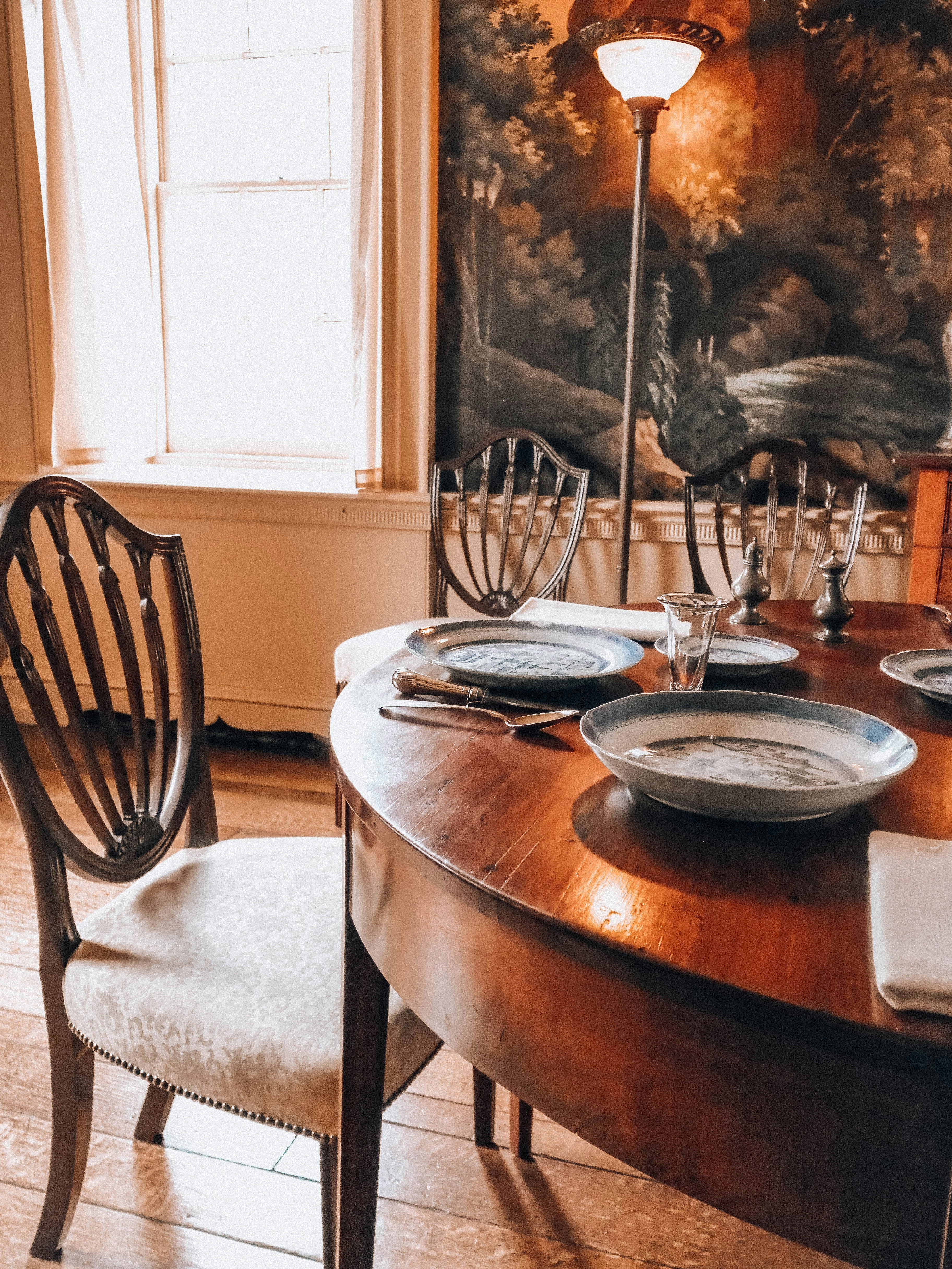 A Quiet Dinner Set Under a Warm Lamp in an Antiques-Filled Dining Room