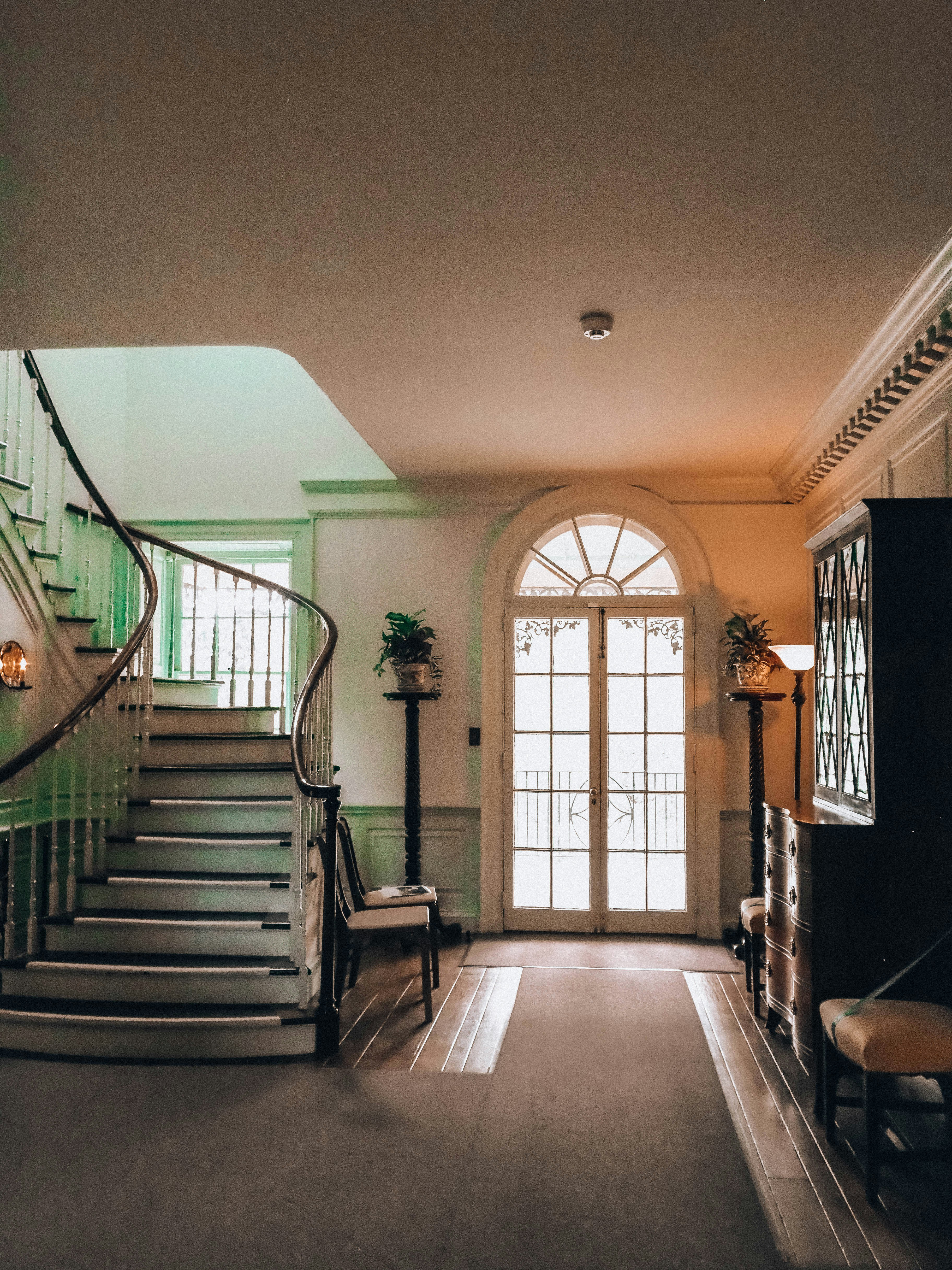Grand foyer with curved staircase and glass-pated doors