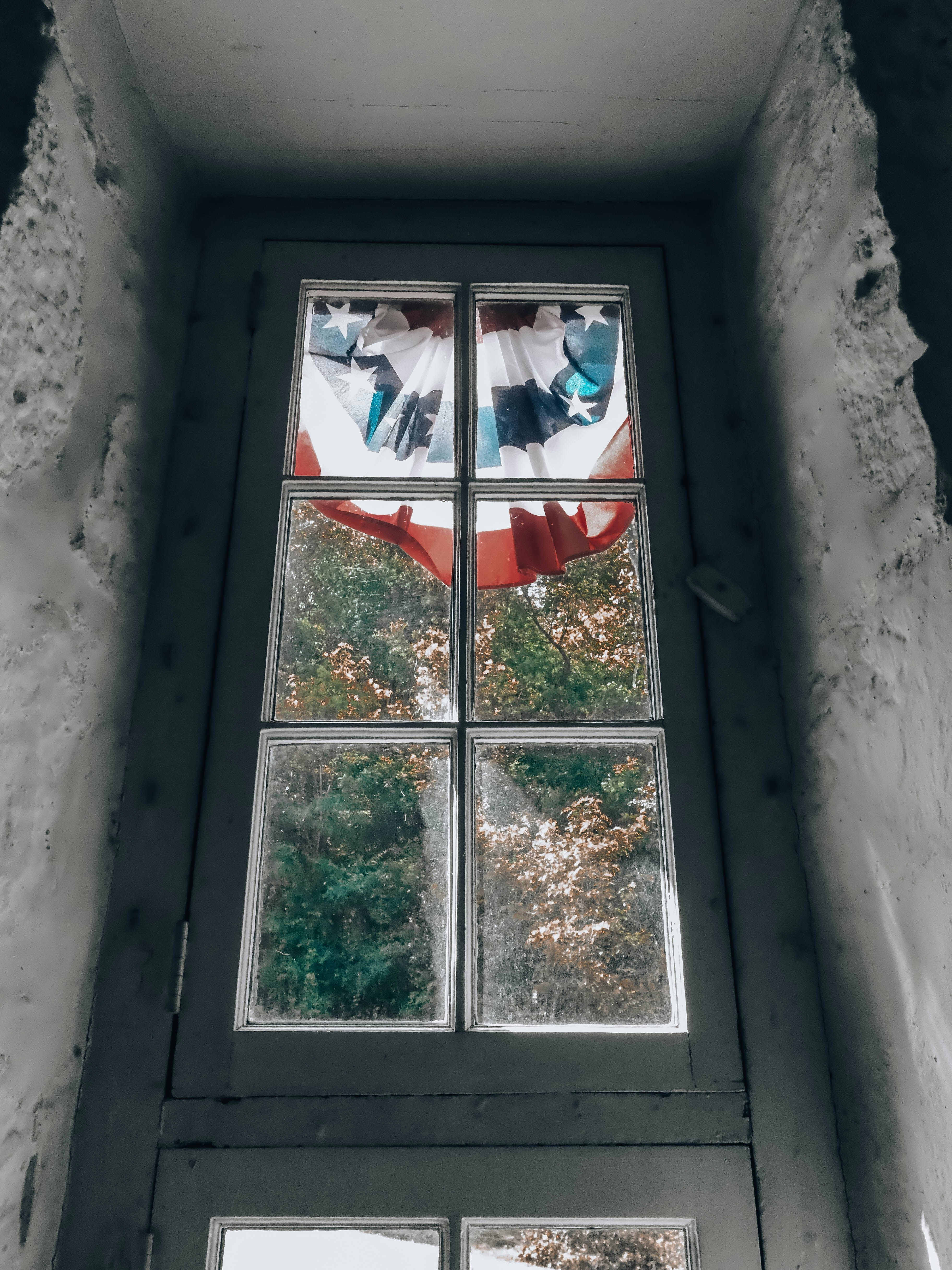 A Window Toward Autumn: Flags Framed by Stone and Glass