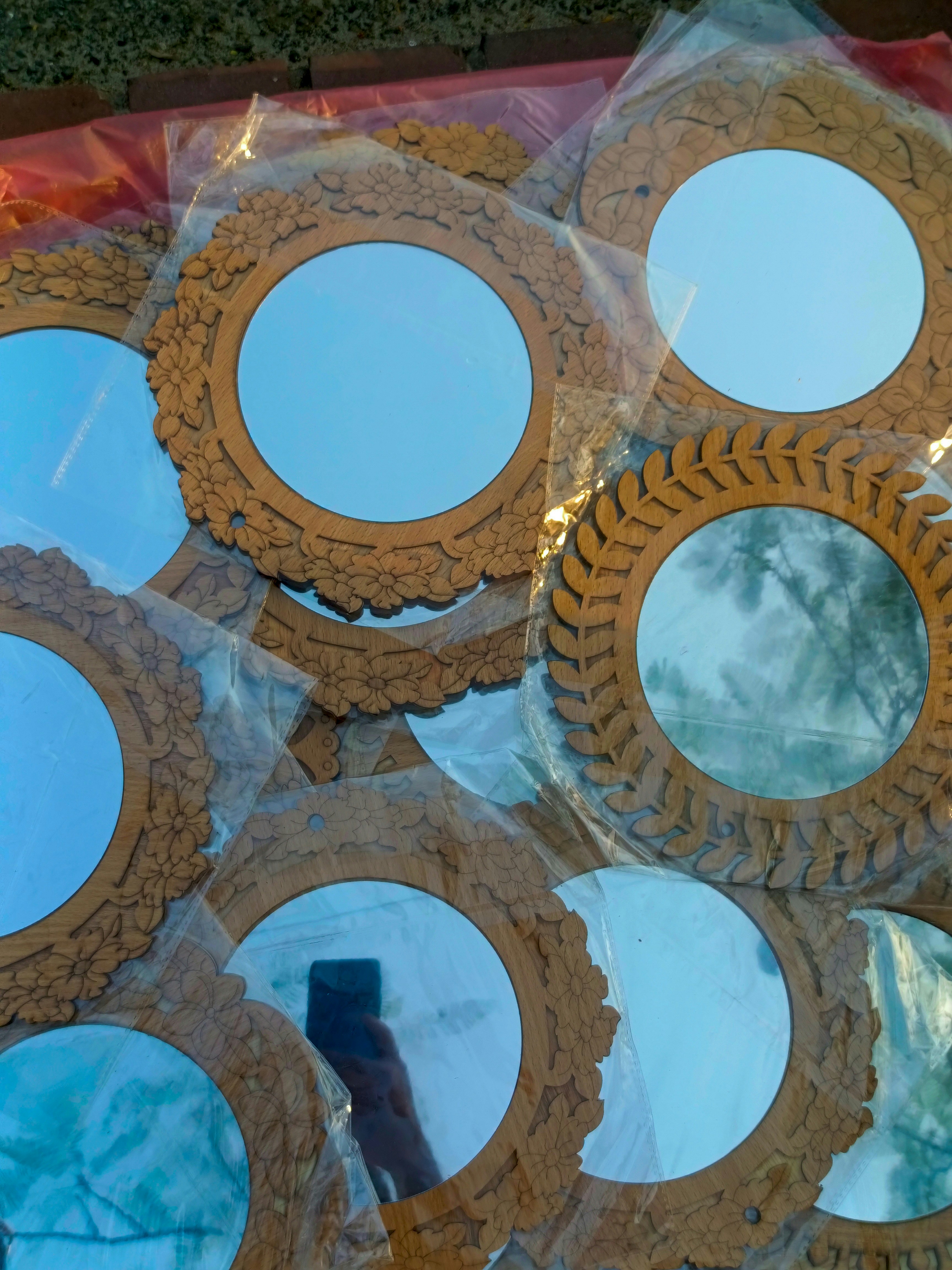 Carved wooden circular frames arranged in a layered pattern with mirrored blue reflections visible through the centers.