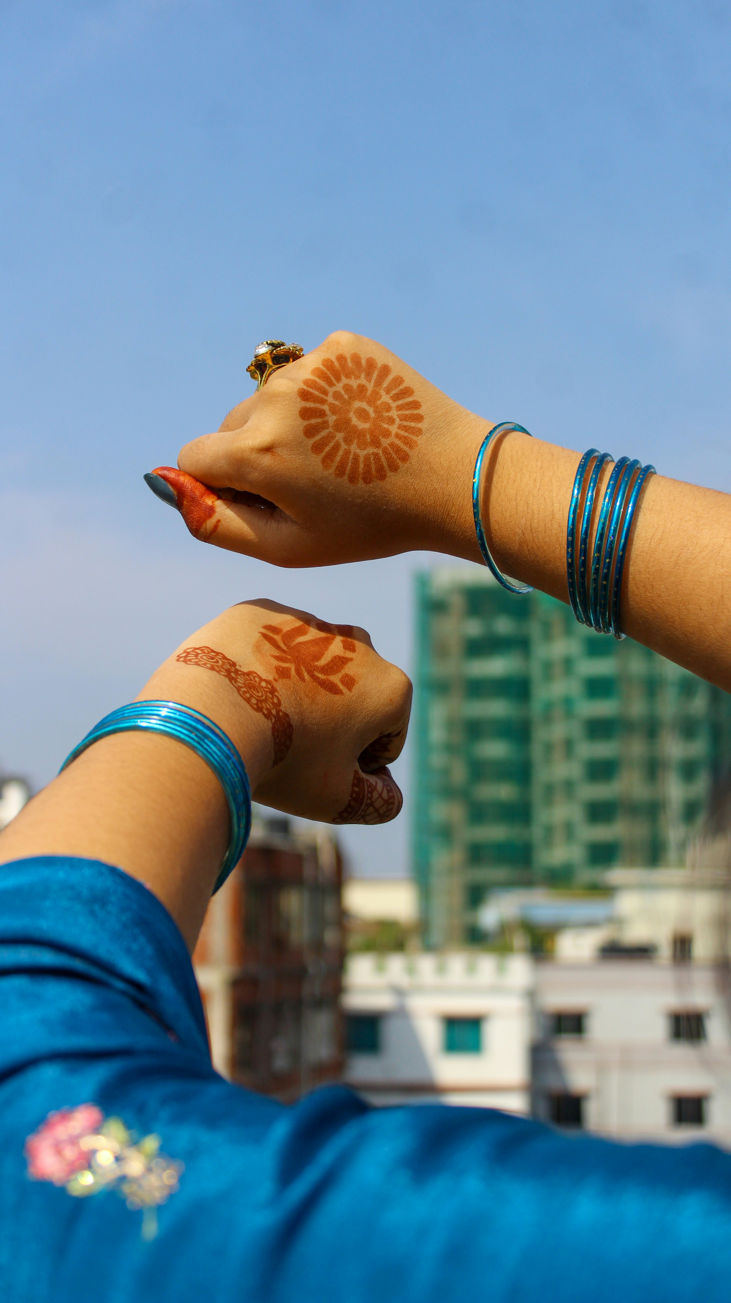 Hennaed Hands Lifted Against a Sky of Blue