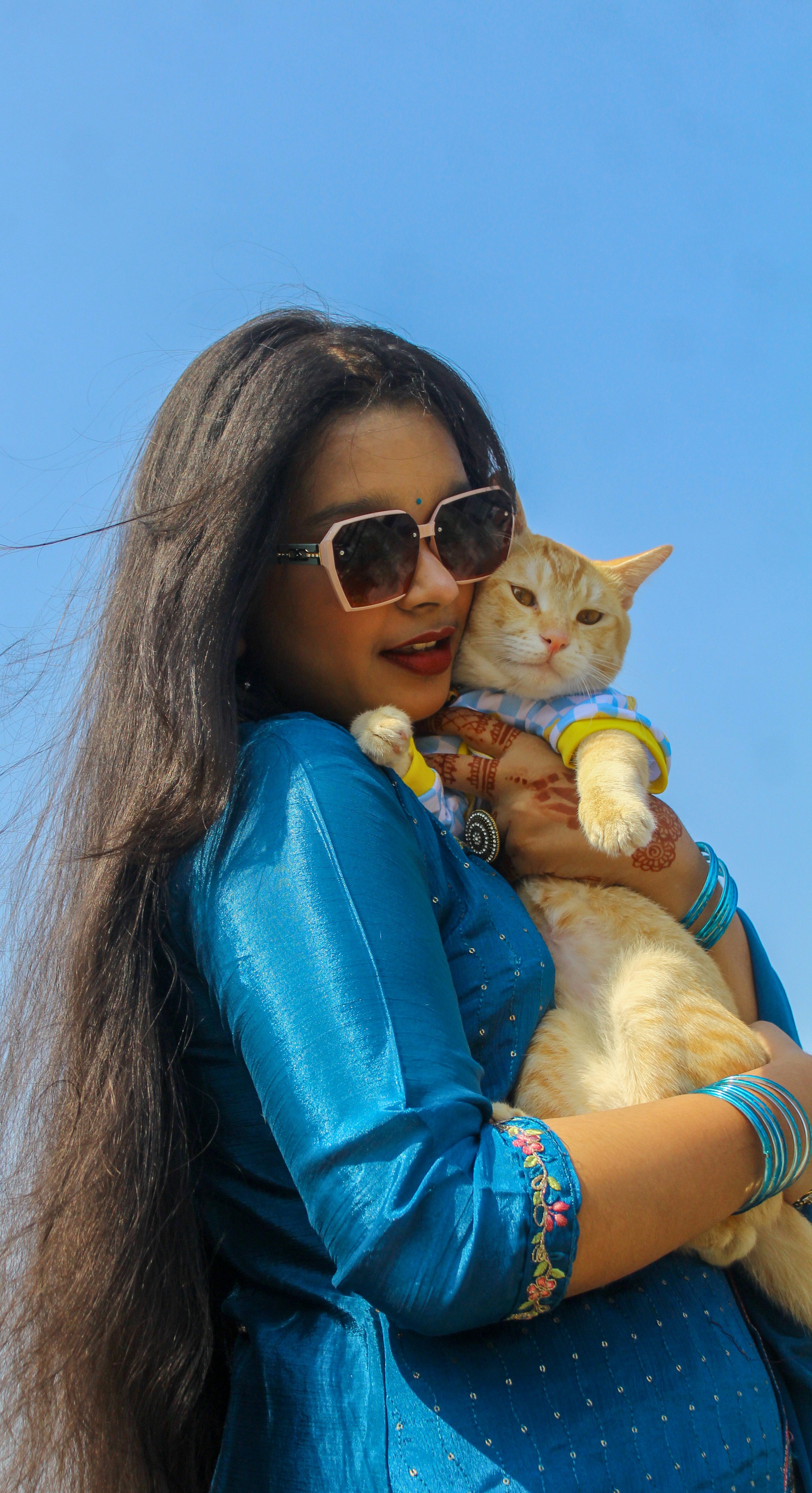 Sunkissed Smile: A Woman and Cat in a Bright Cyan Moment