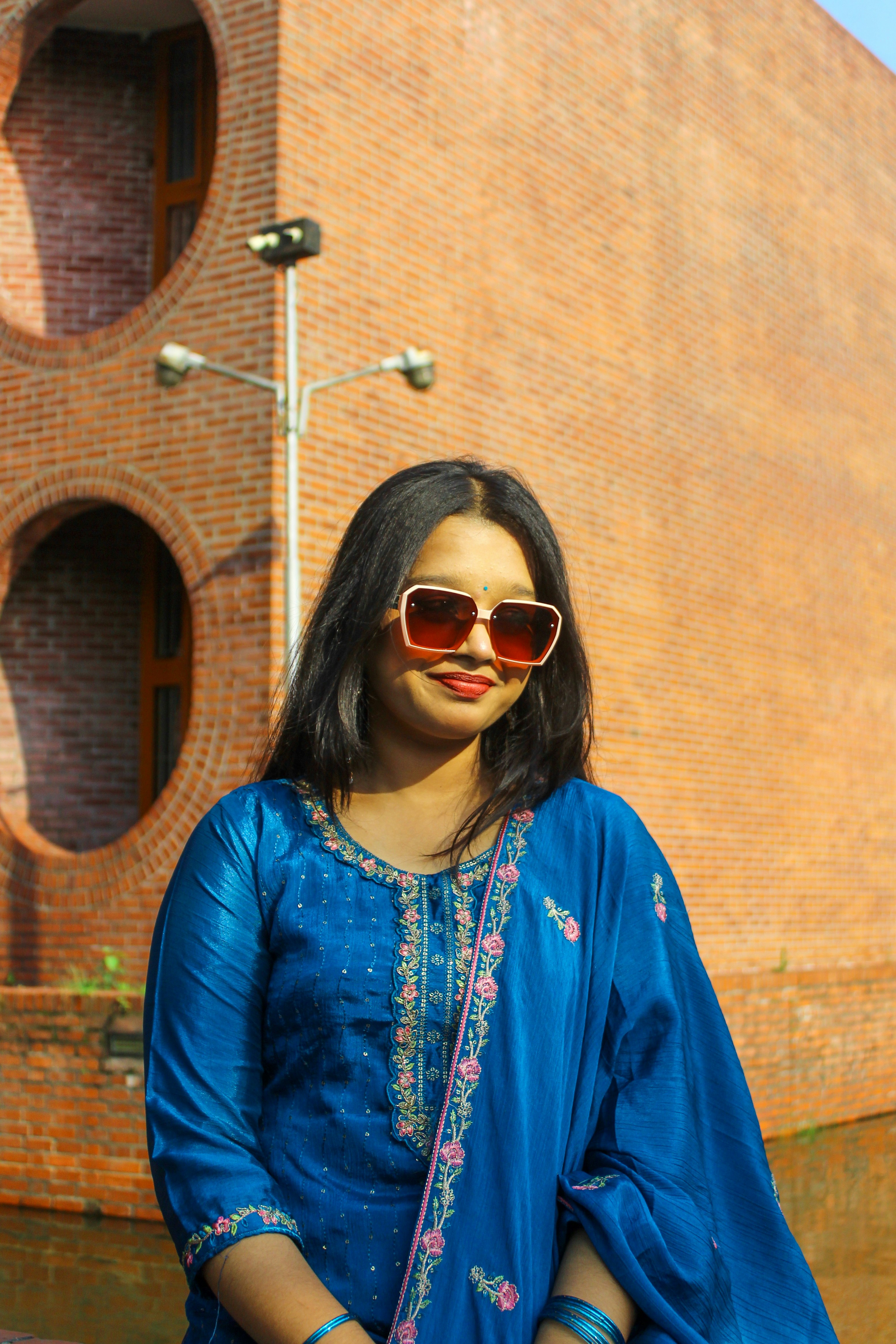 Blue Attire, Bright Lens: A Portrait by the Brick Archway
