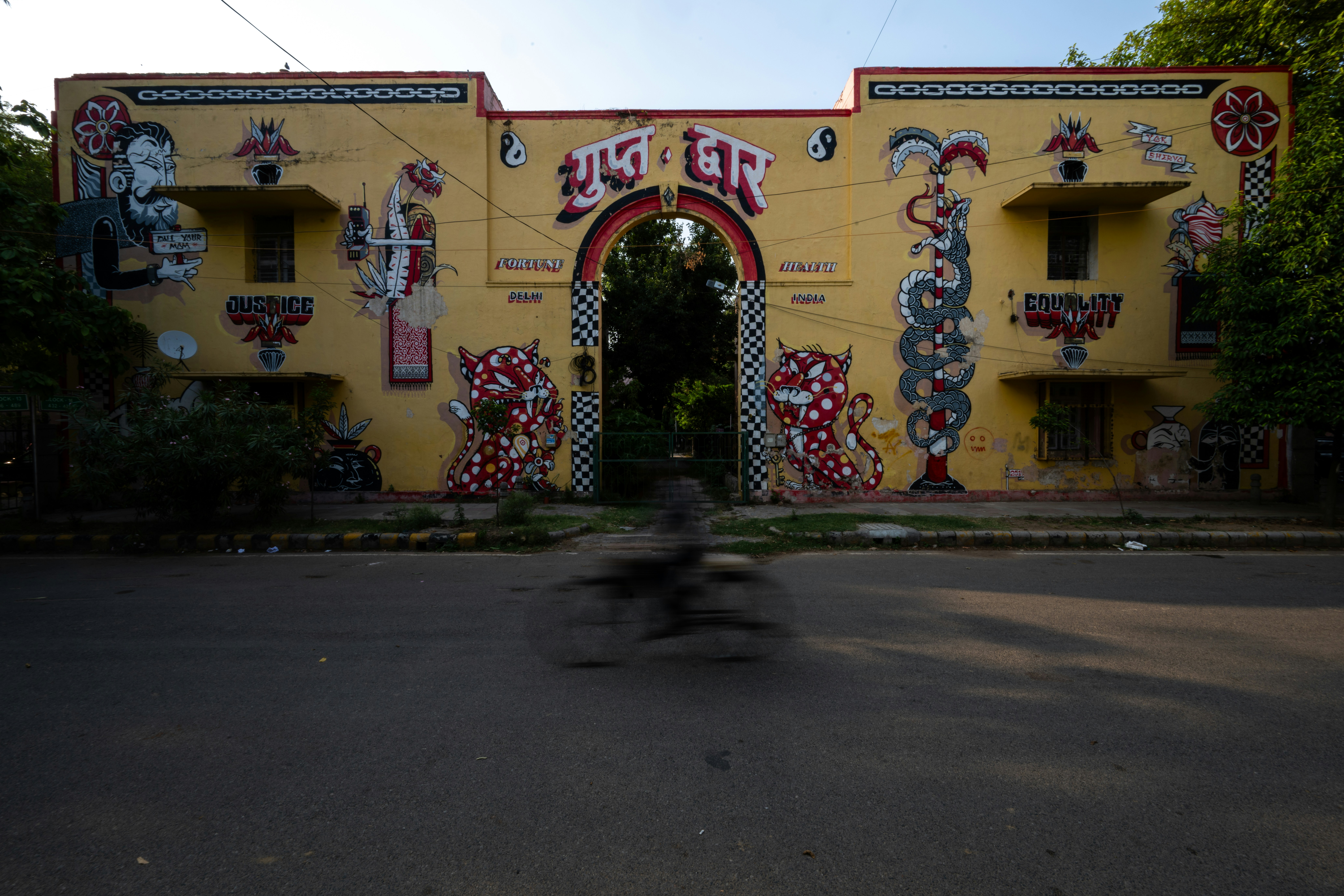 Colorful Archway of Murals: A Quiet Street beneath a Bustling Portal