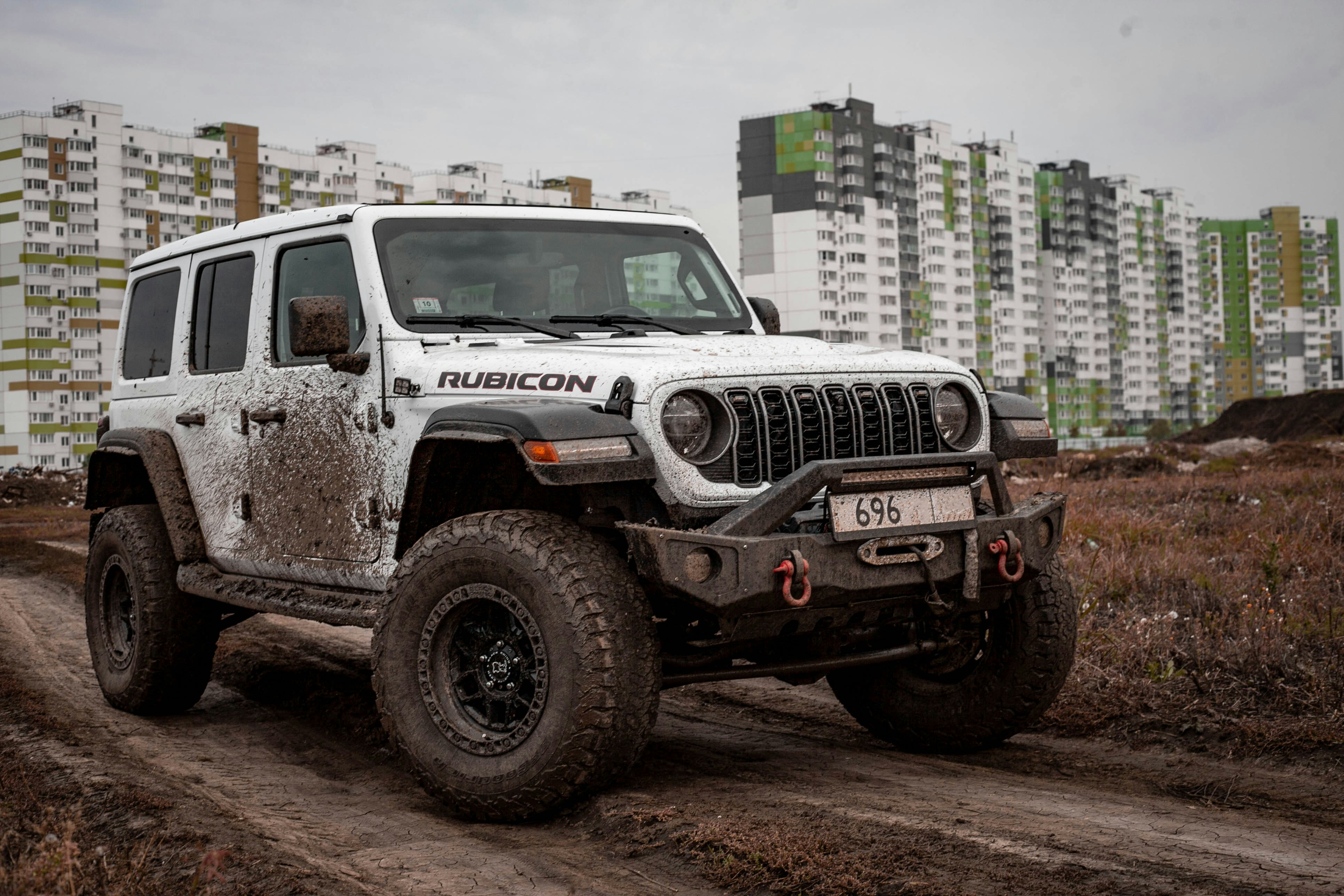 Mud-Splashed Jeep Rubicon Confronts an Urban Horizon