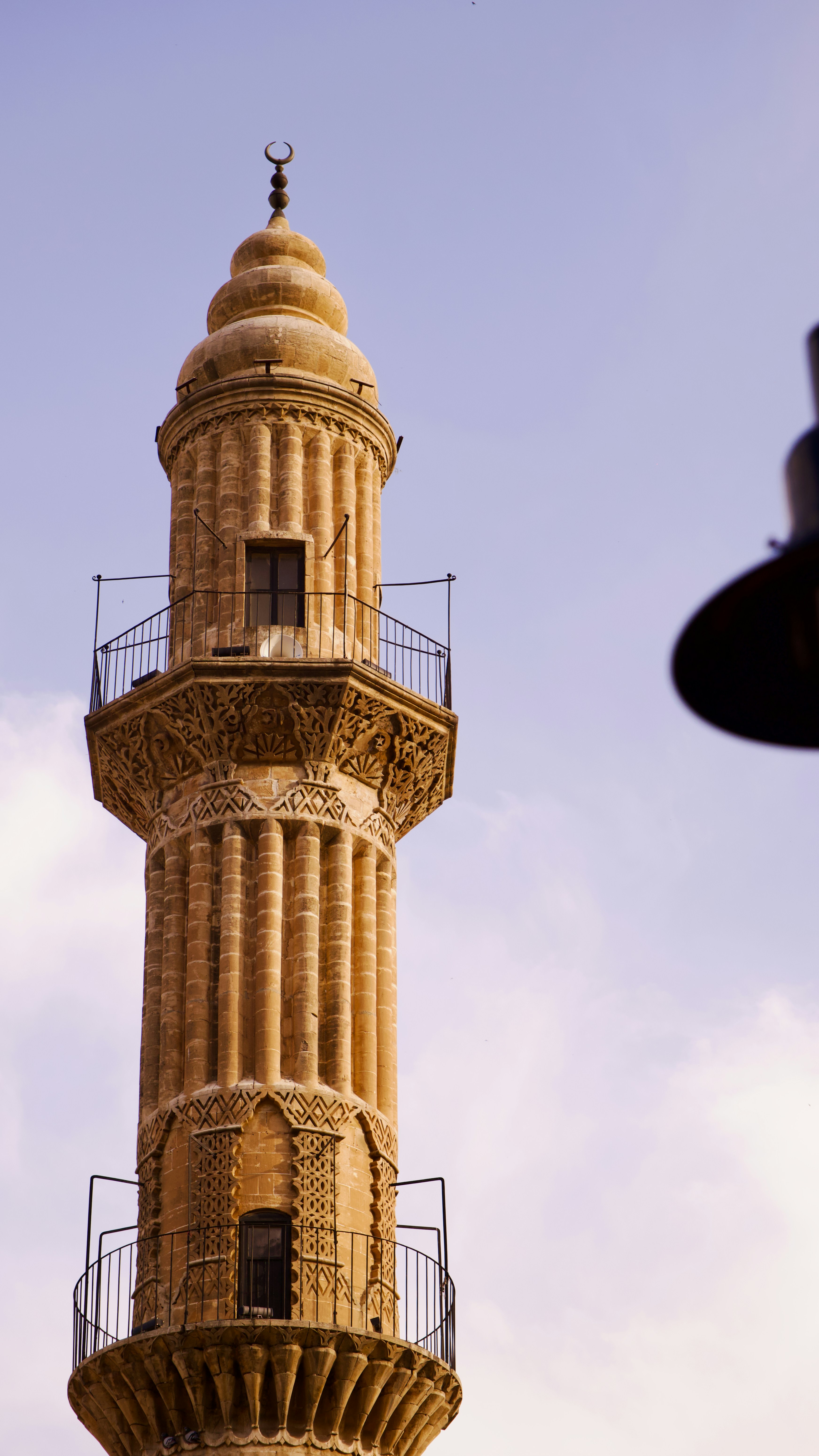 Tower of Echoes: A Sunlit Minaret Rising into the Pale Sky